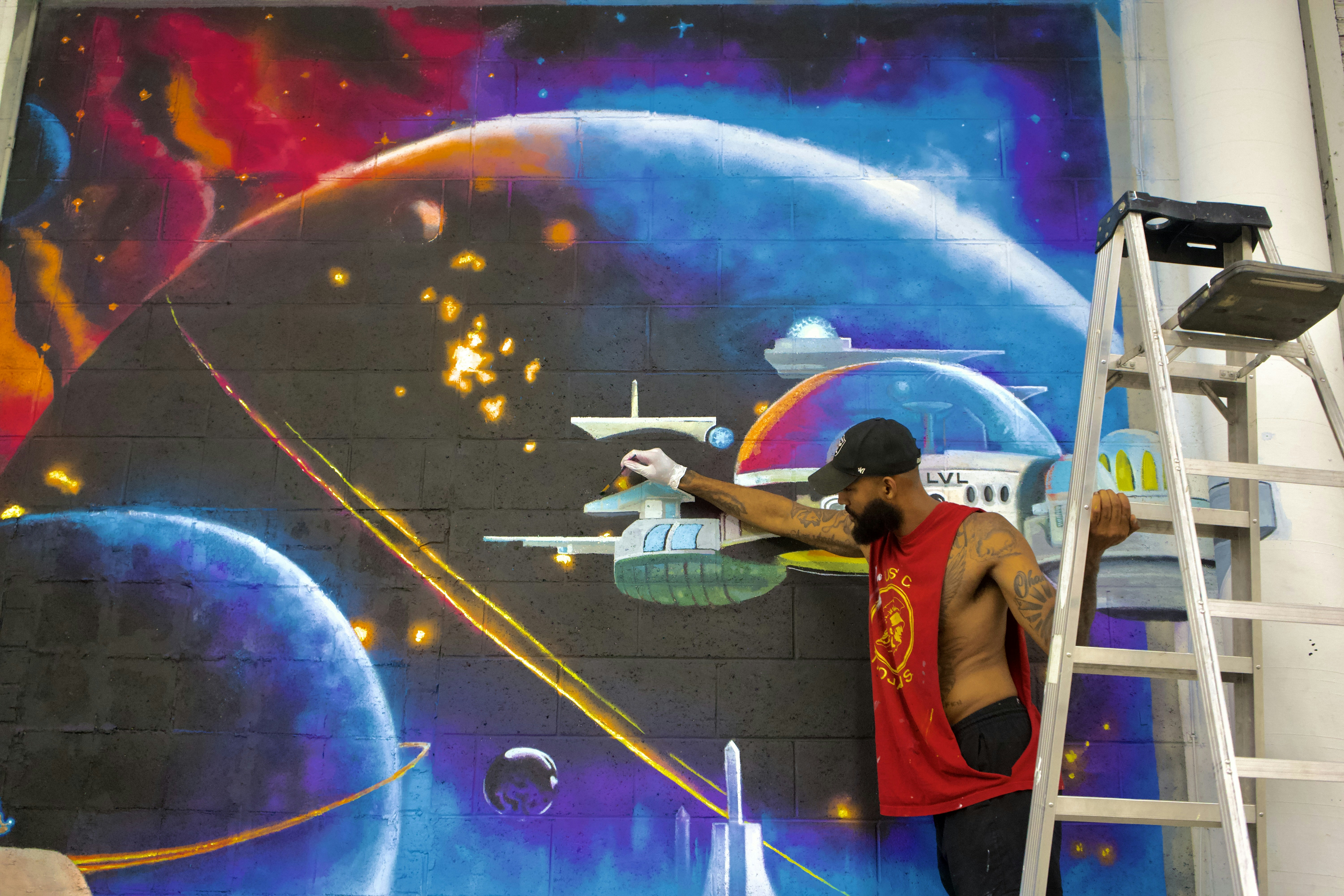 Painter on the Edge: Cosmic Wall Drama with a Vibrant Astral Scene