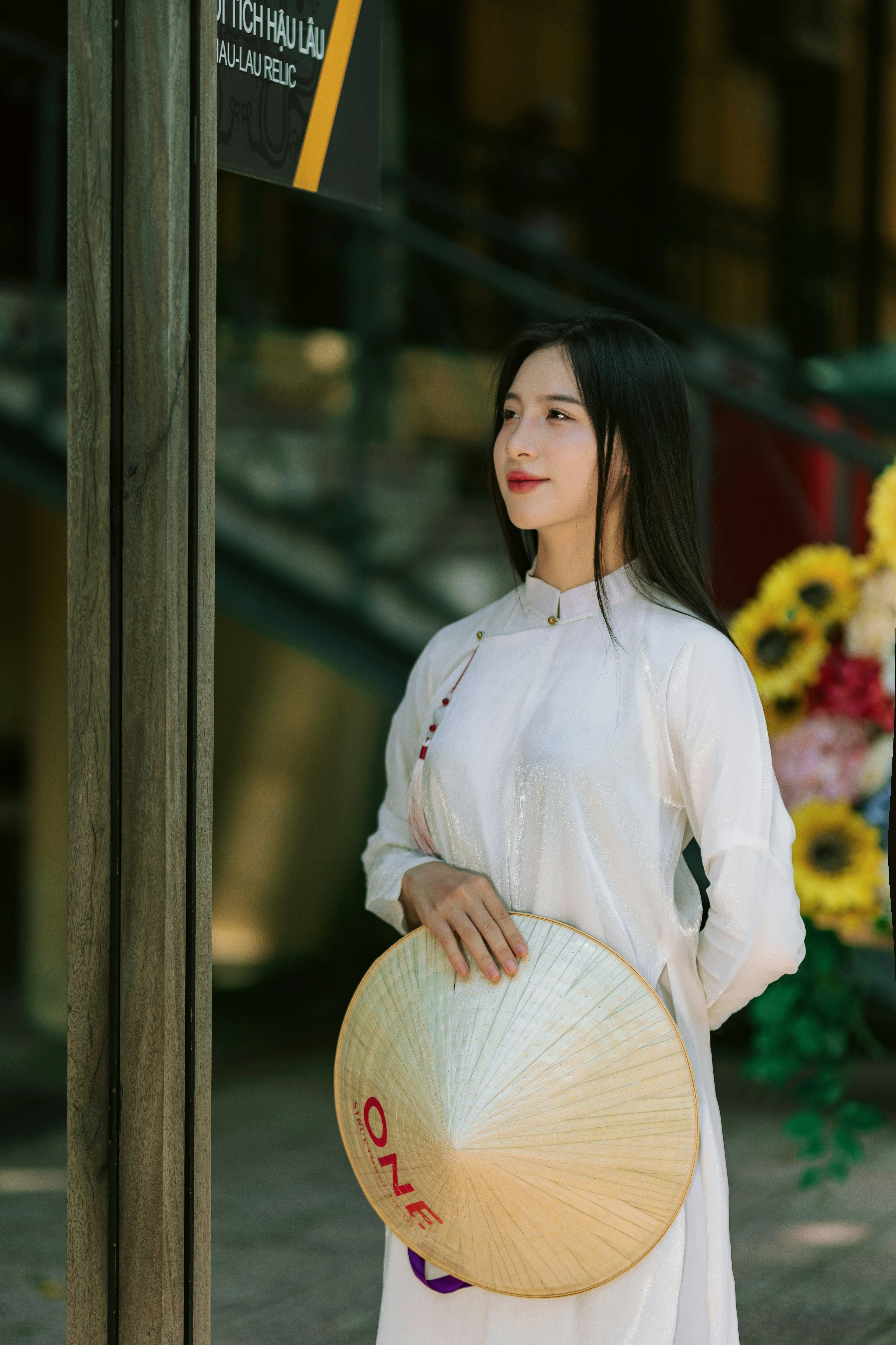 Quiet Grace in White: Ao Dai and Nón Lá against a Sunflower Backdrop