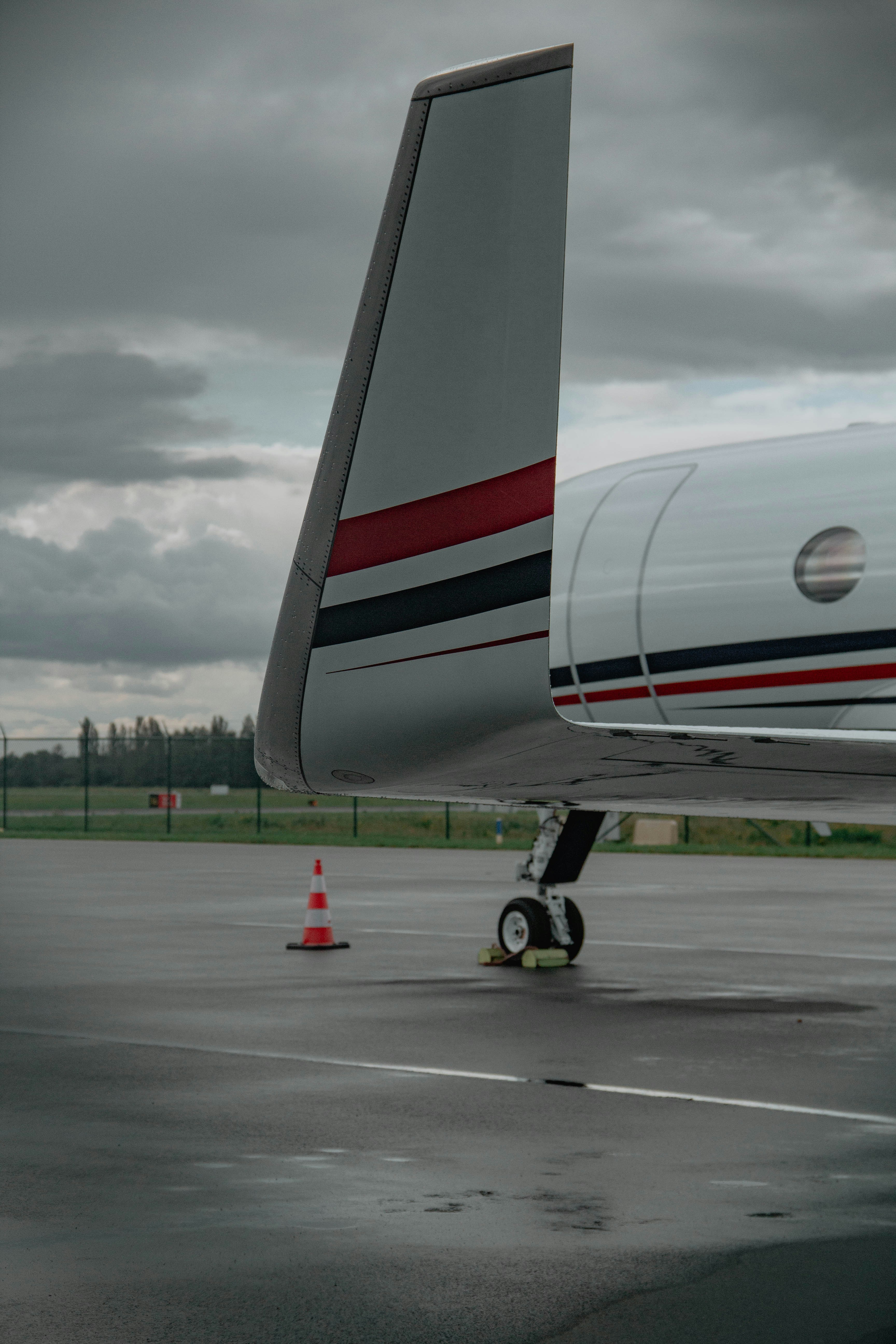 Tailfin on a Rainy Ramp: Stripes, Silence, and a Static Jet