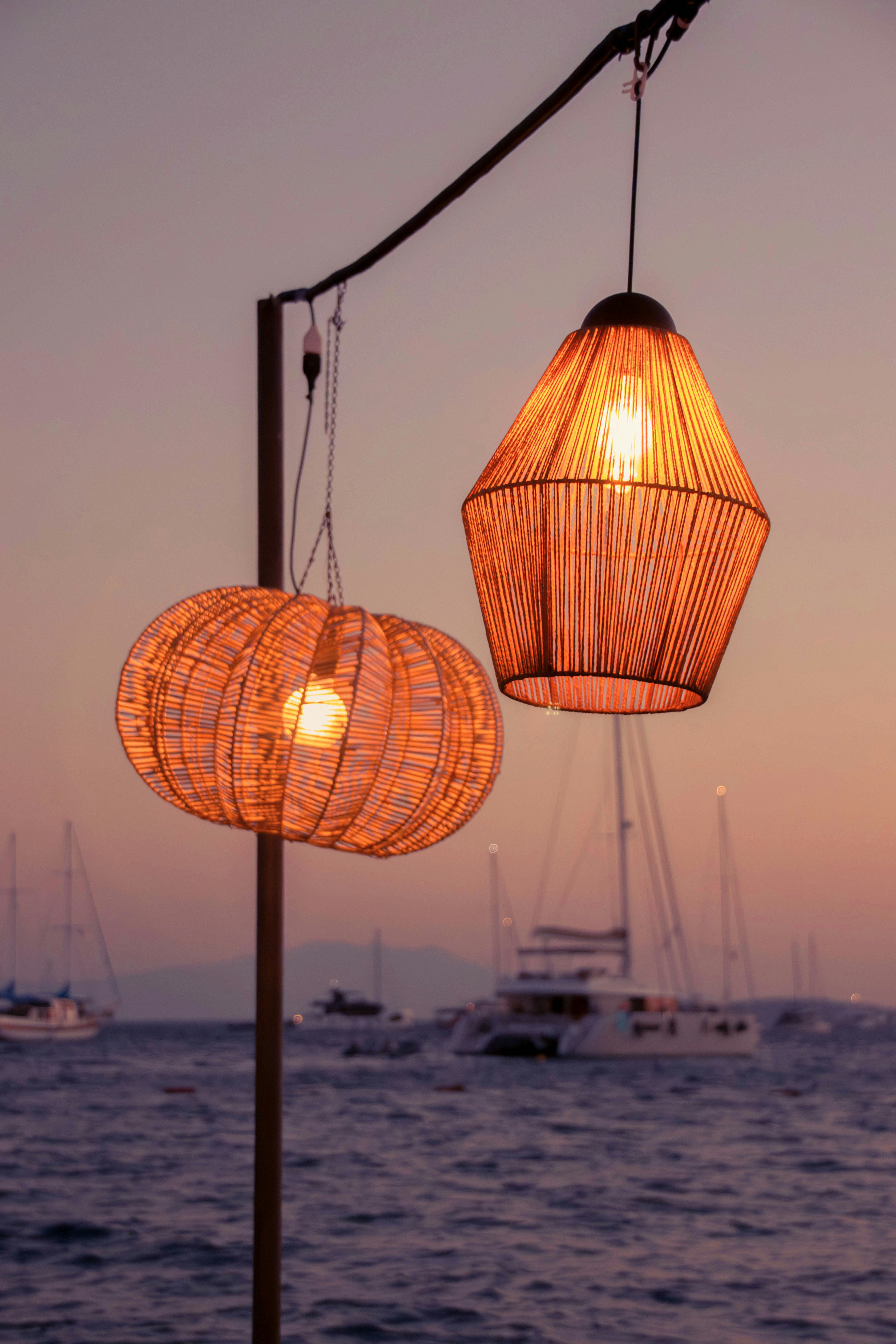 Two Amber Lanterns Illuminate a Quiet Marina at Sunset