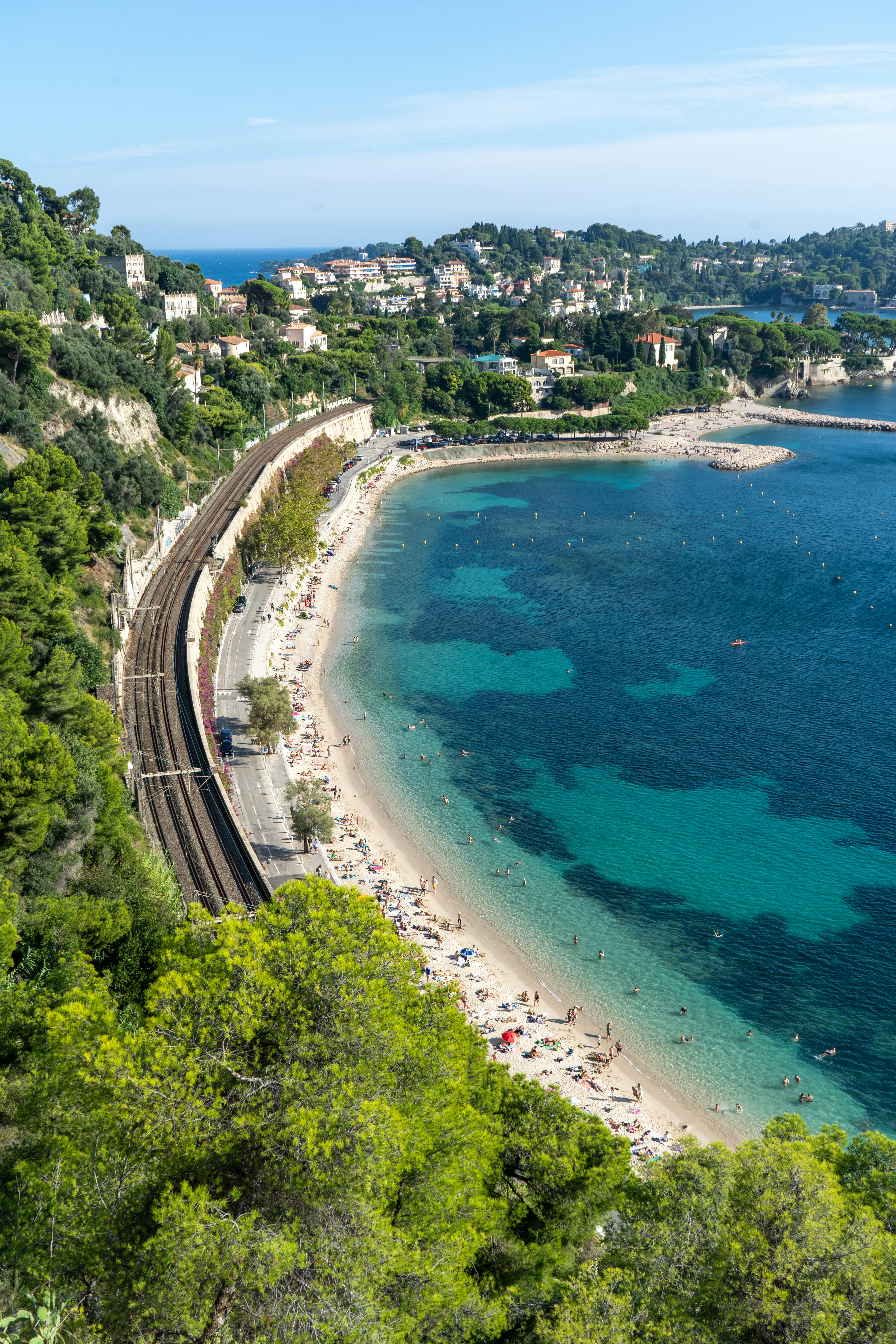 Coastal Rails and Turquoise Cove: A Cliffside Riviera Scene
