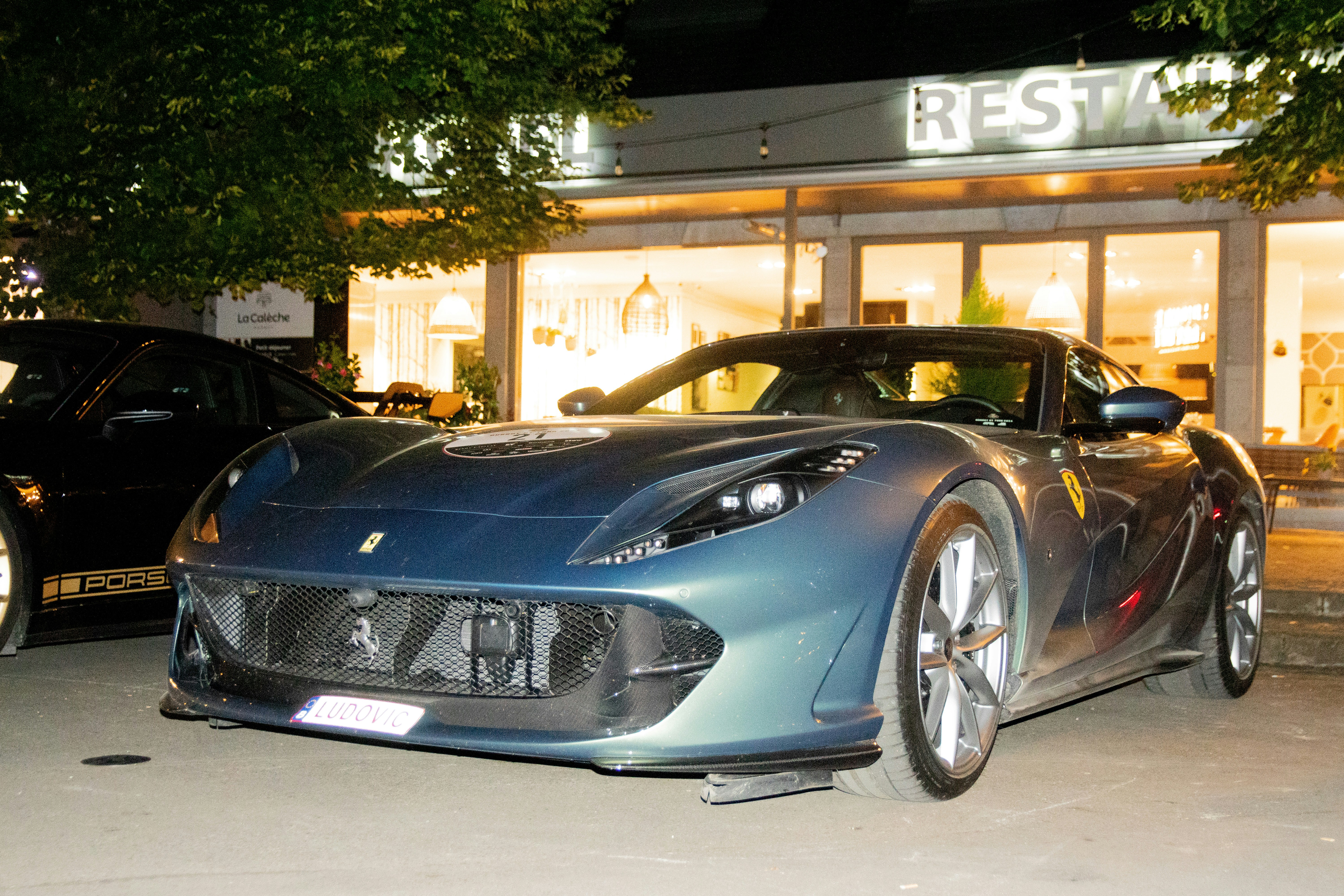 Blue Ferrari Portico: A Night-drive Redcar in Front of a Well-Lit Storefront