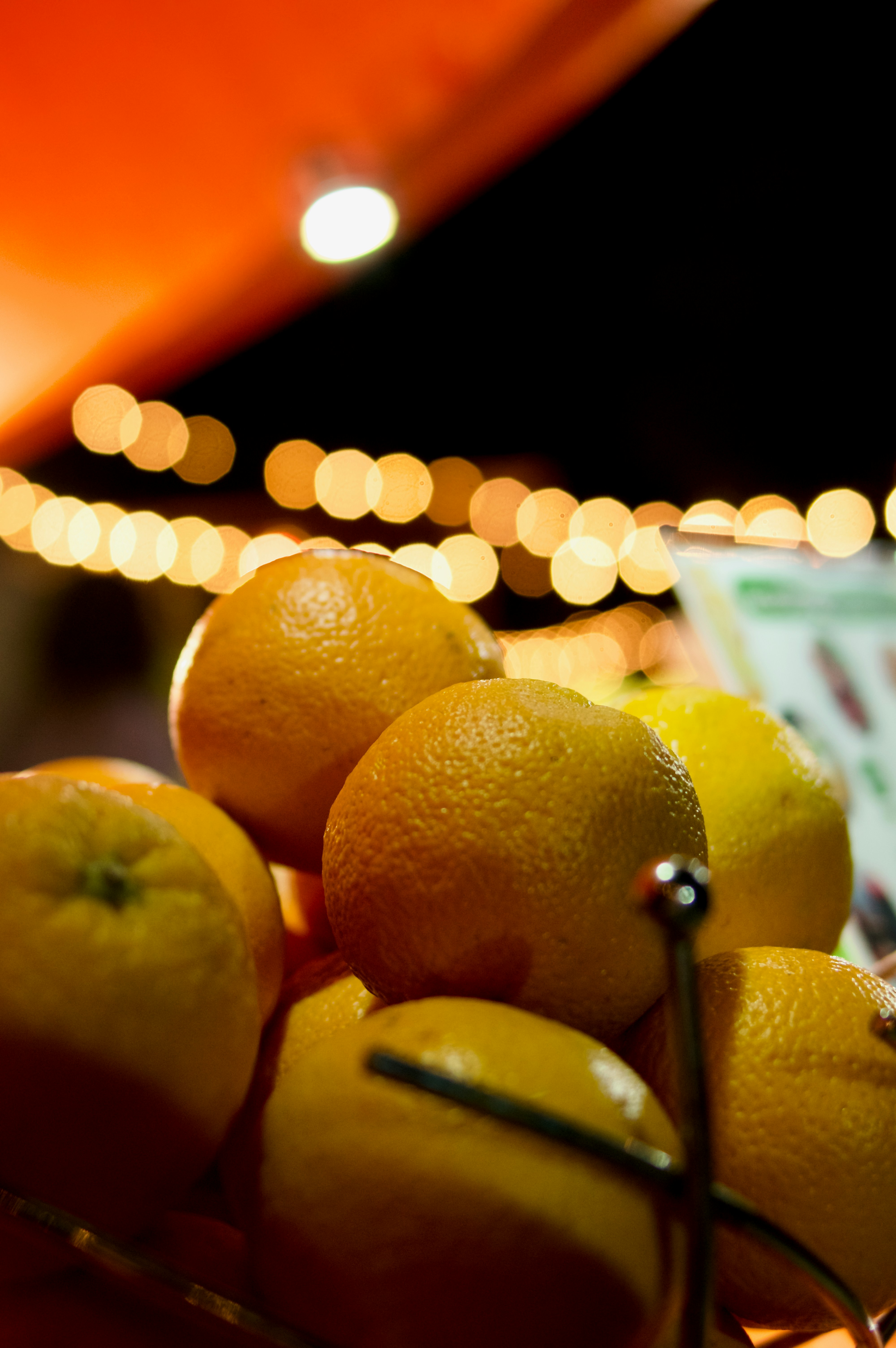 Oranges Under Night Market Lights: A Close-Up with Velvet Bokeh