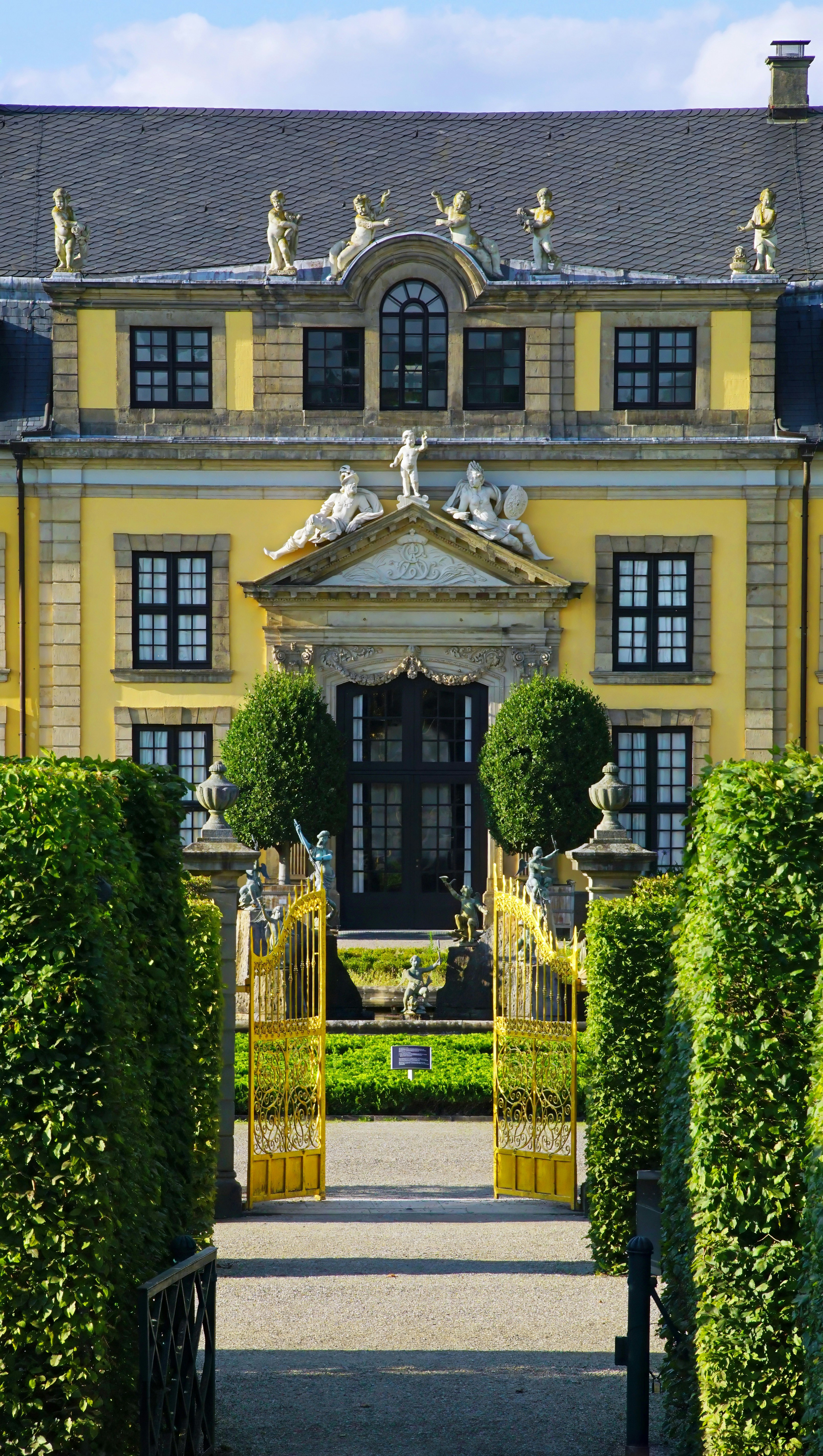 Golden Gates, Yellow Facade: A Baroque Estate Framed by Sculpted Guardians