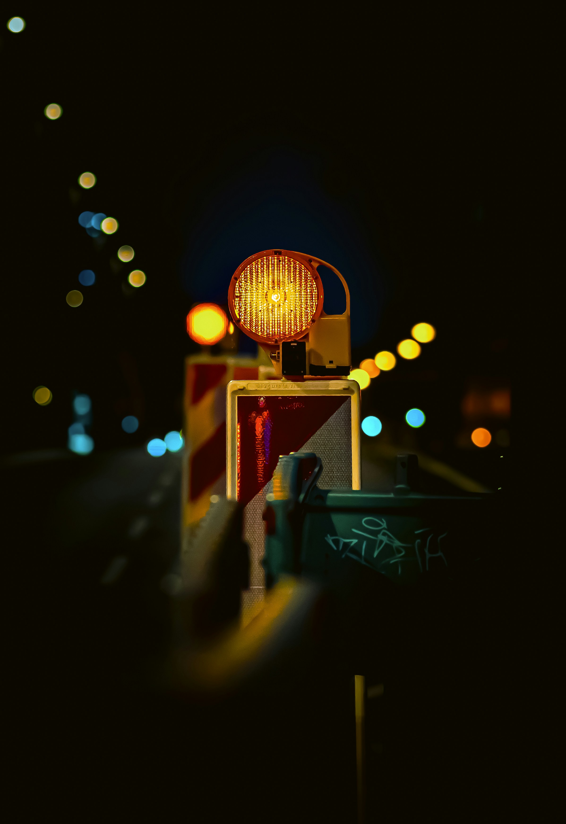 Lone Amber Beacon on a Night-Washed Construction Barrier