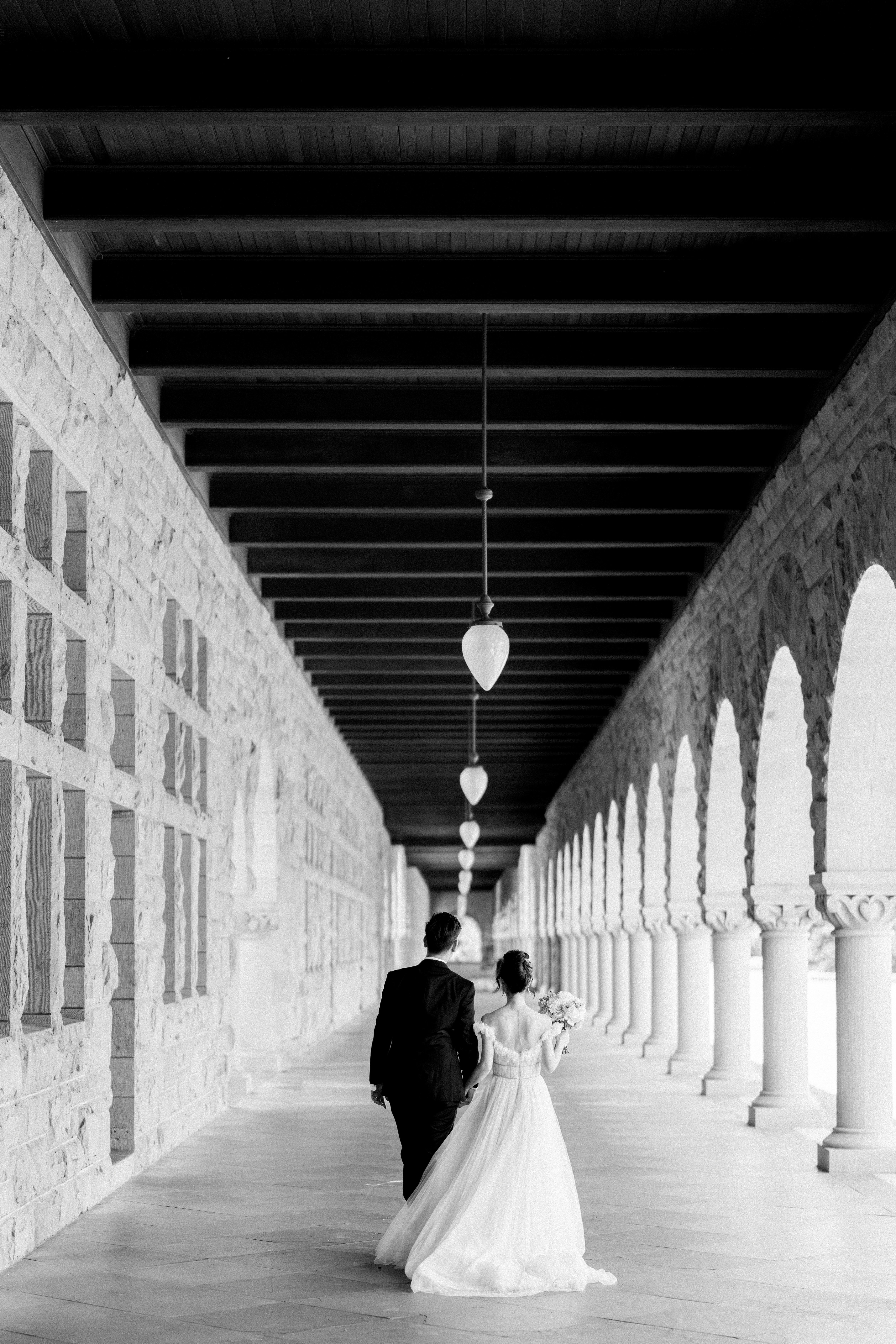 Une mariée et un marié marchant dans un long couloir photo – Image ...