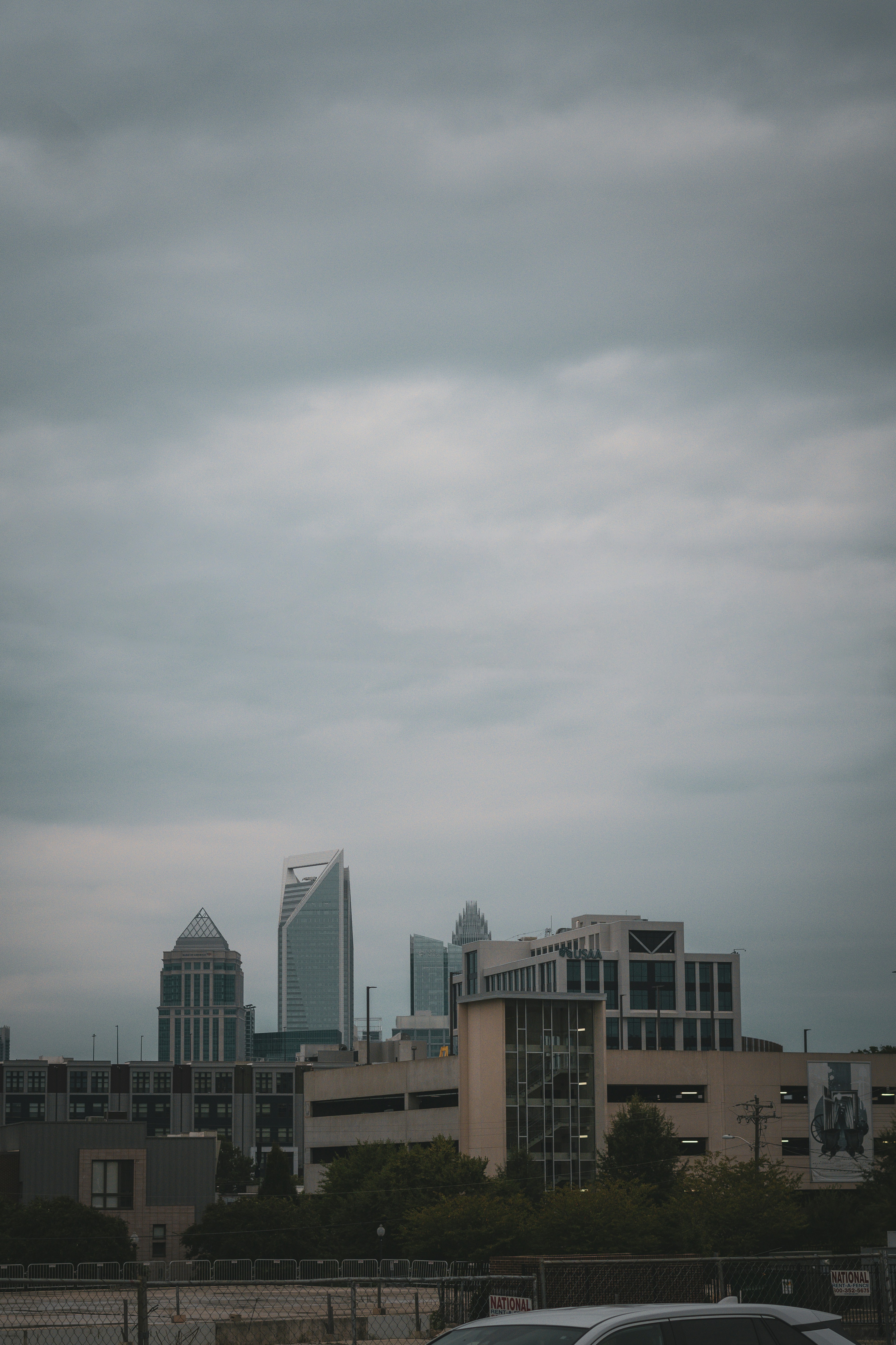 Overcast Skyline: Glass Towers Rise Above a Quiet Industrial Foreground