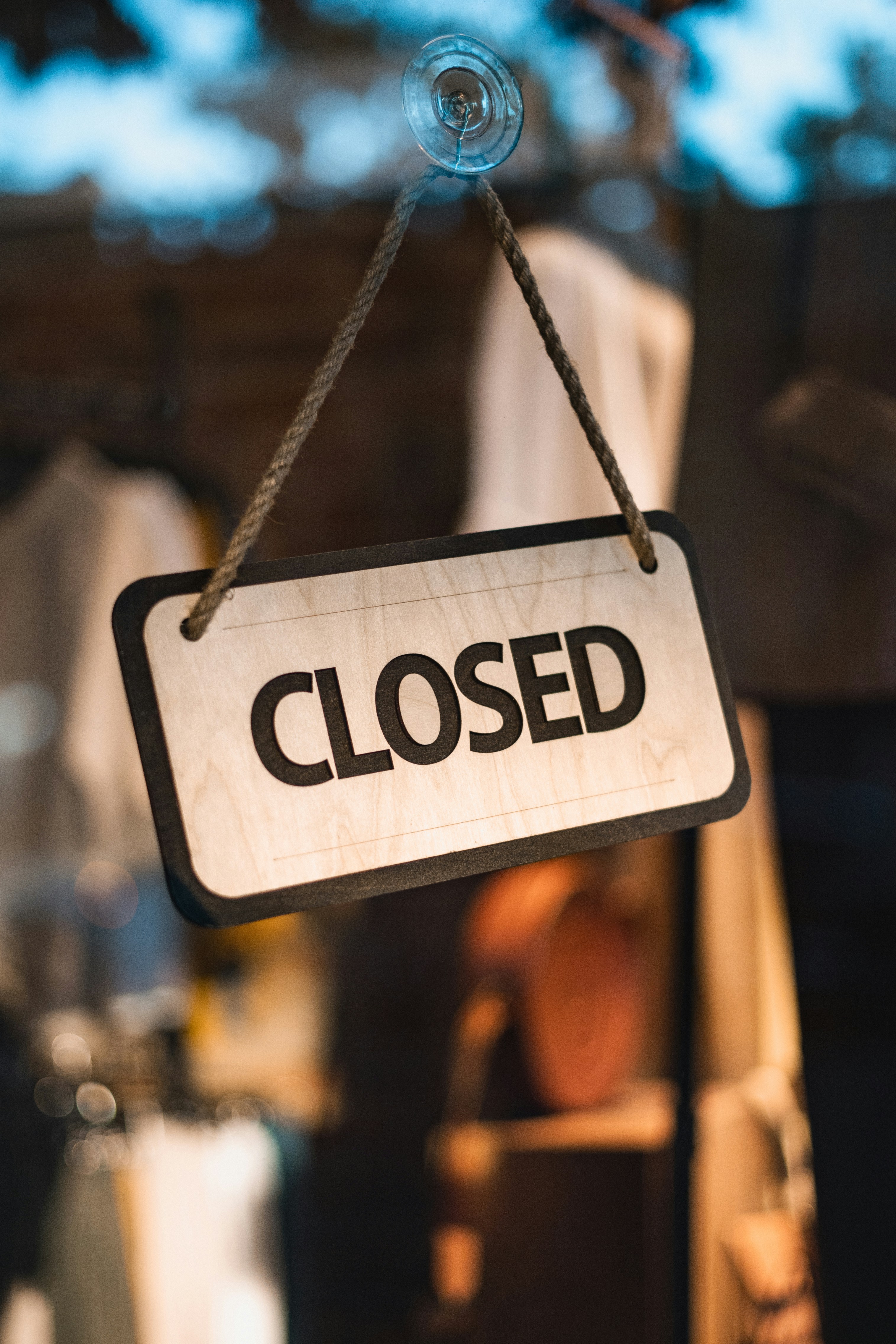 A close up of a closed sign hanging from a rope photo – Free Sign Image ...