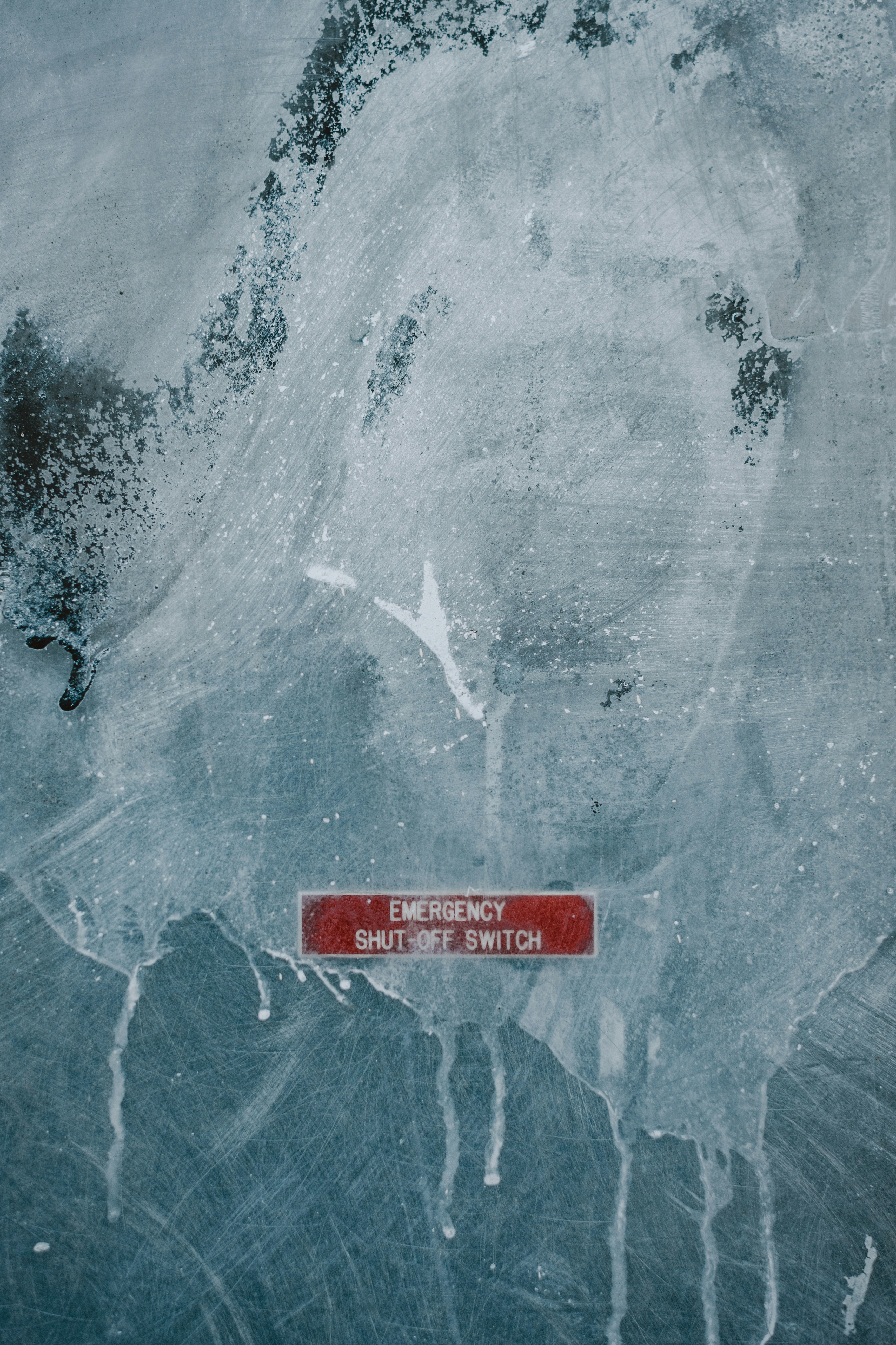 Red emergency shut-off switch on an icy, textured surface.