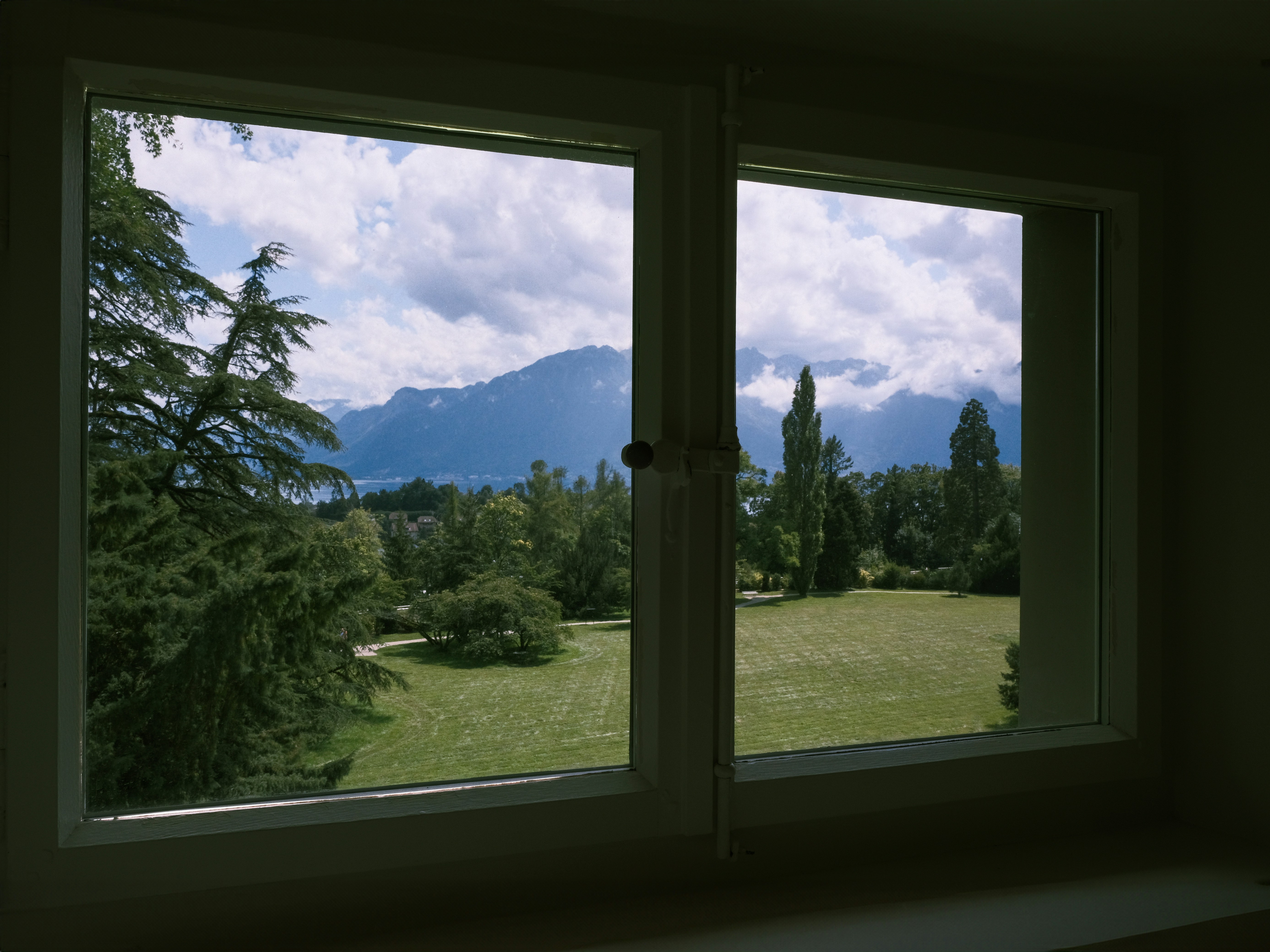 A window with a view of a field and mountains photo – Free Switzerland Image on Unsplash