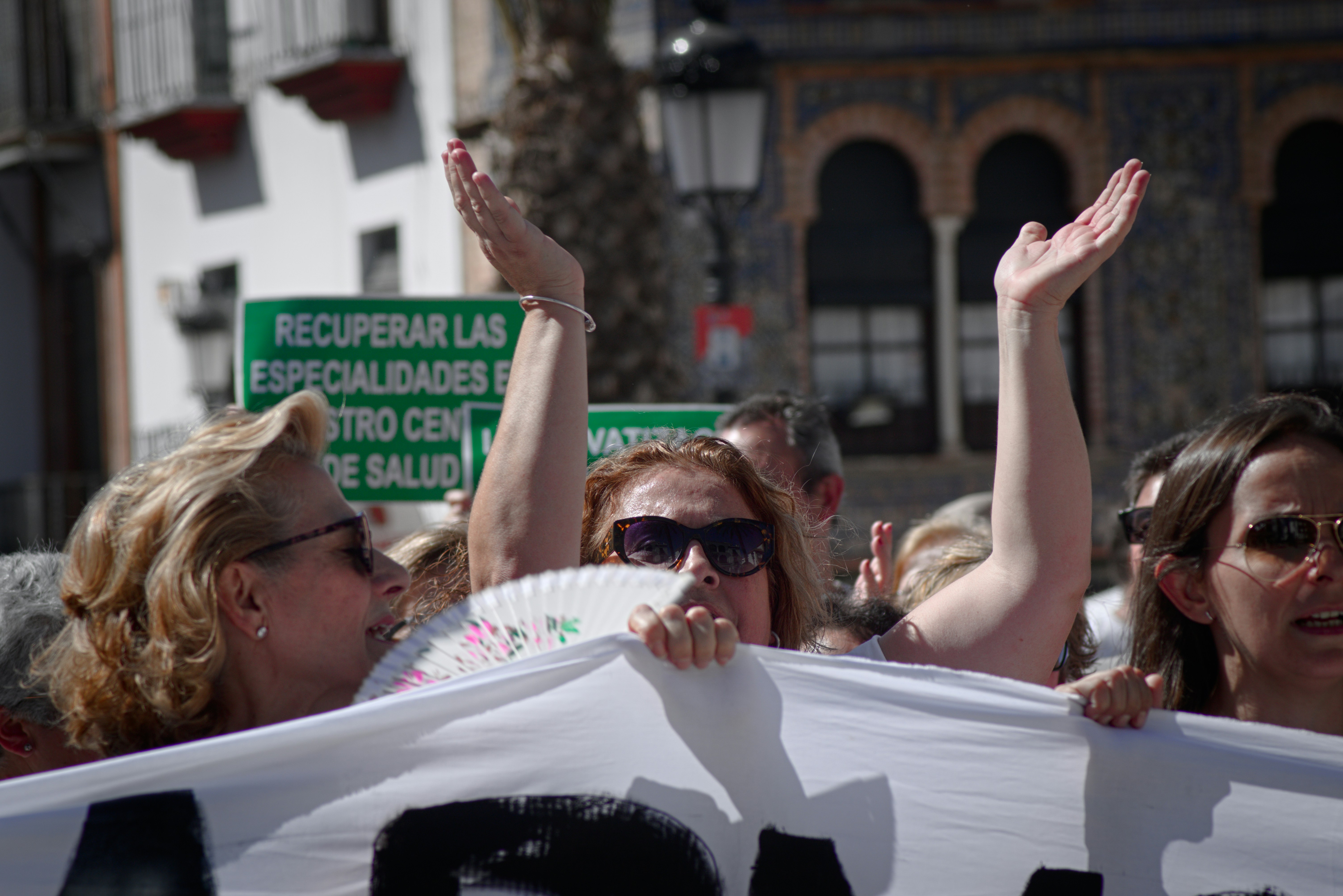 A group of people holding up signs in the street photo – Free Woman ...