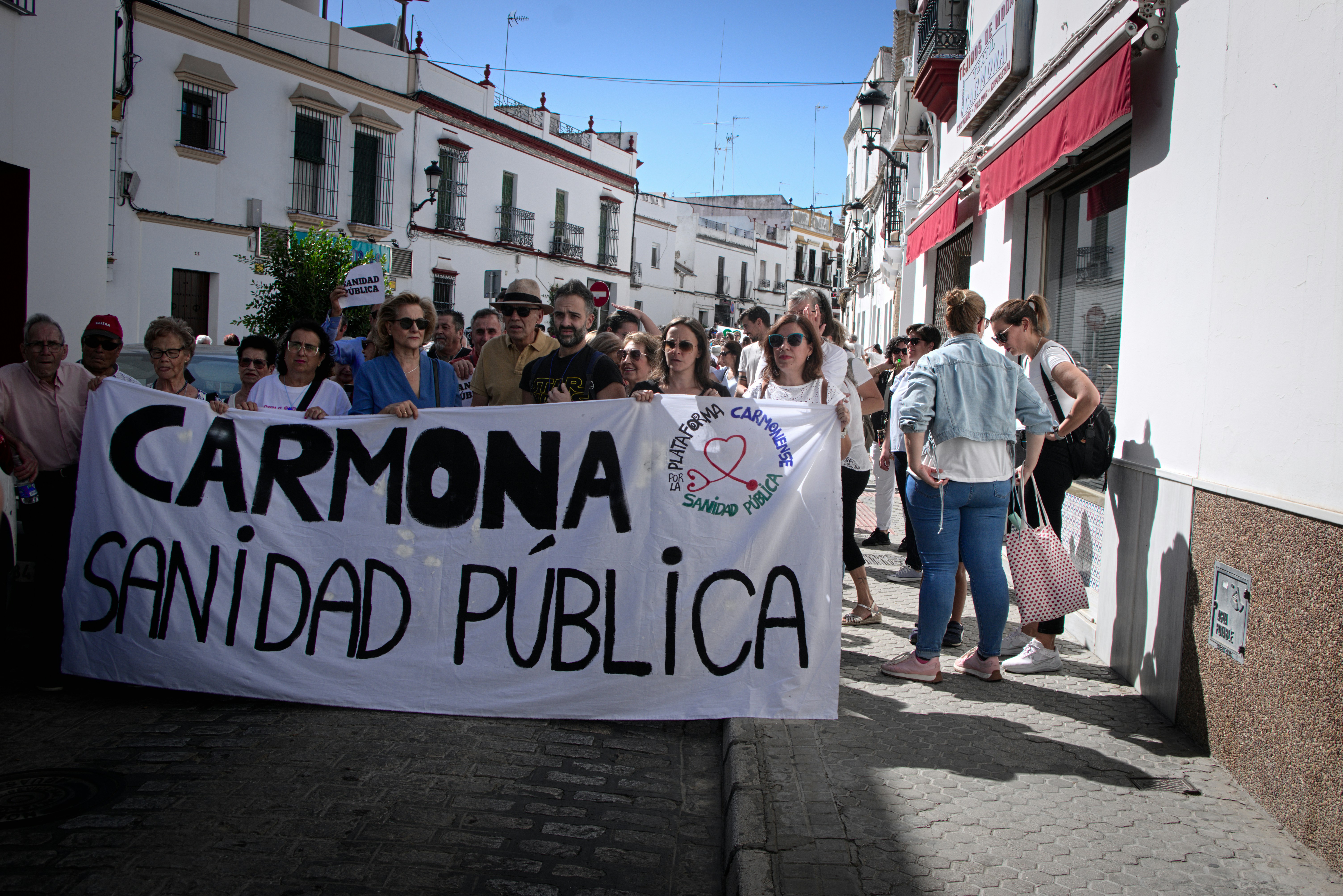 A group of people holding a sign on a street photo – Free Woman Image ...