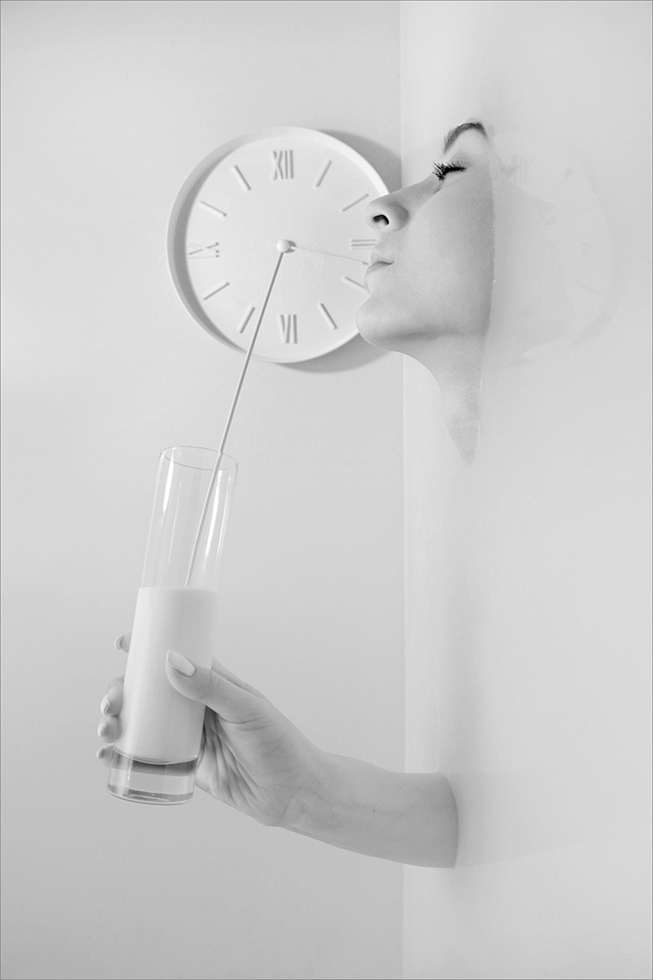 A woman holding a glass of milk and a clock on the wall photo – Free ...