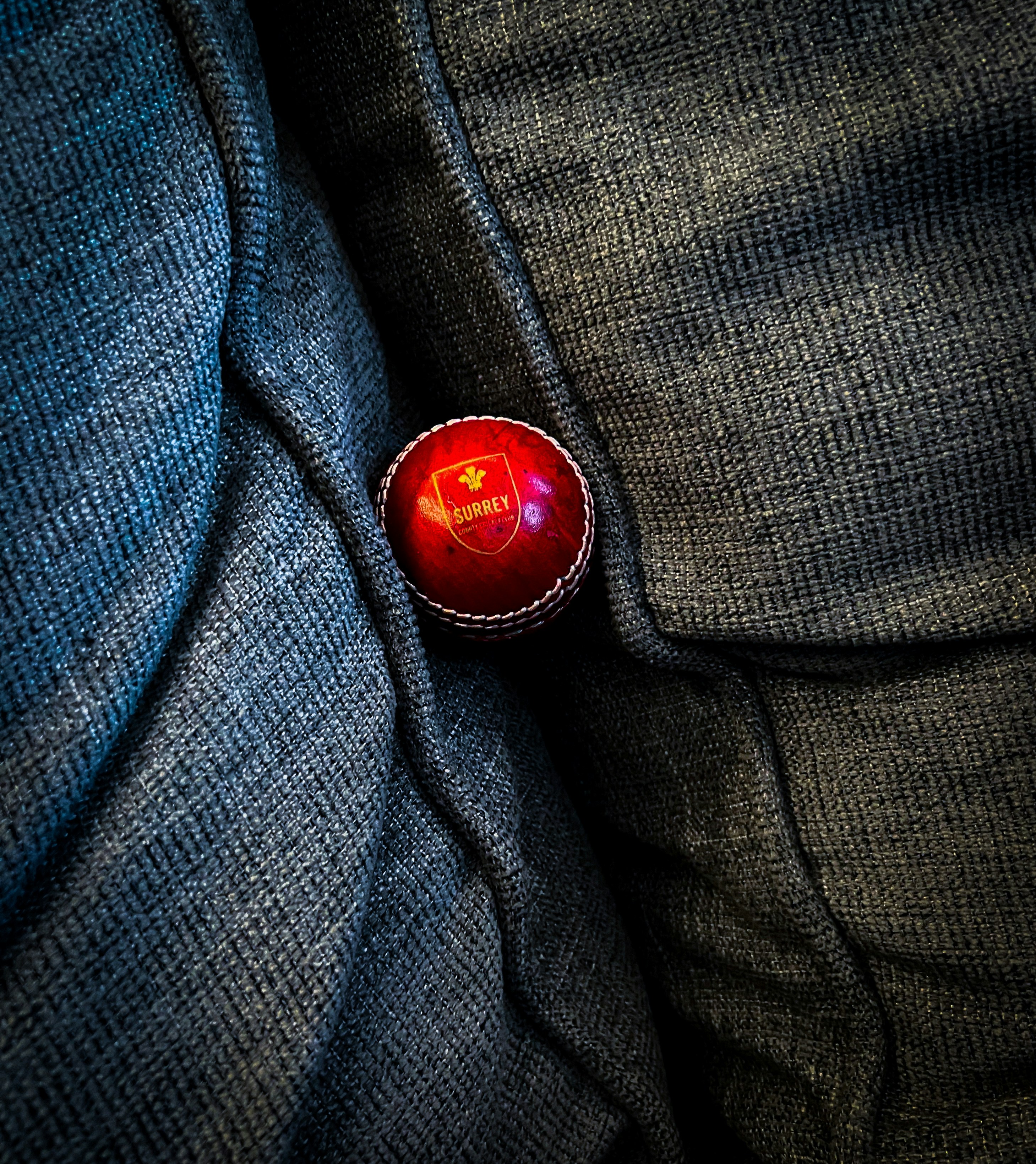 Crimson Ball Nestled Between Denim and Wool