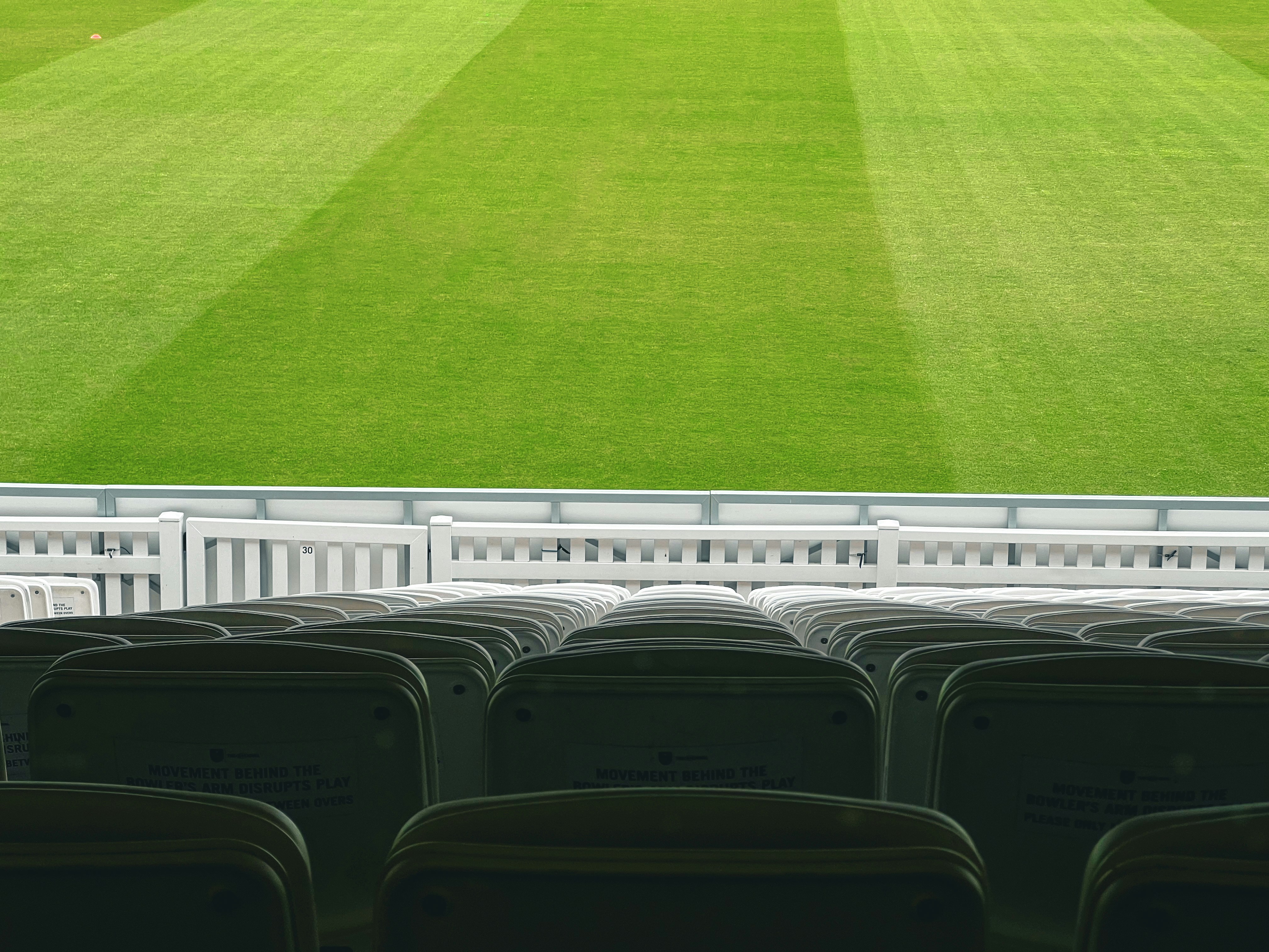 An empty stadium with a green grass field photo – Free London Image on ...