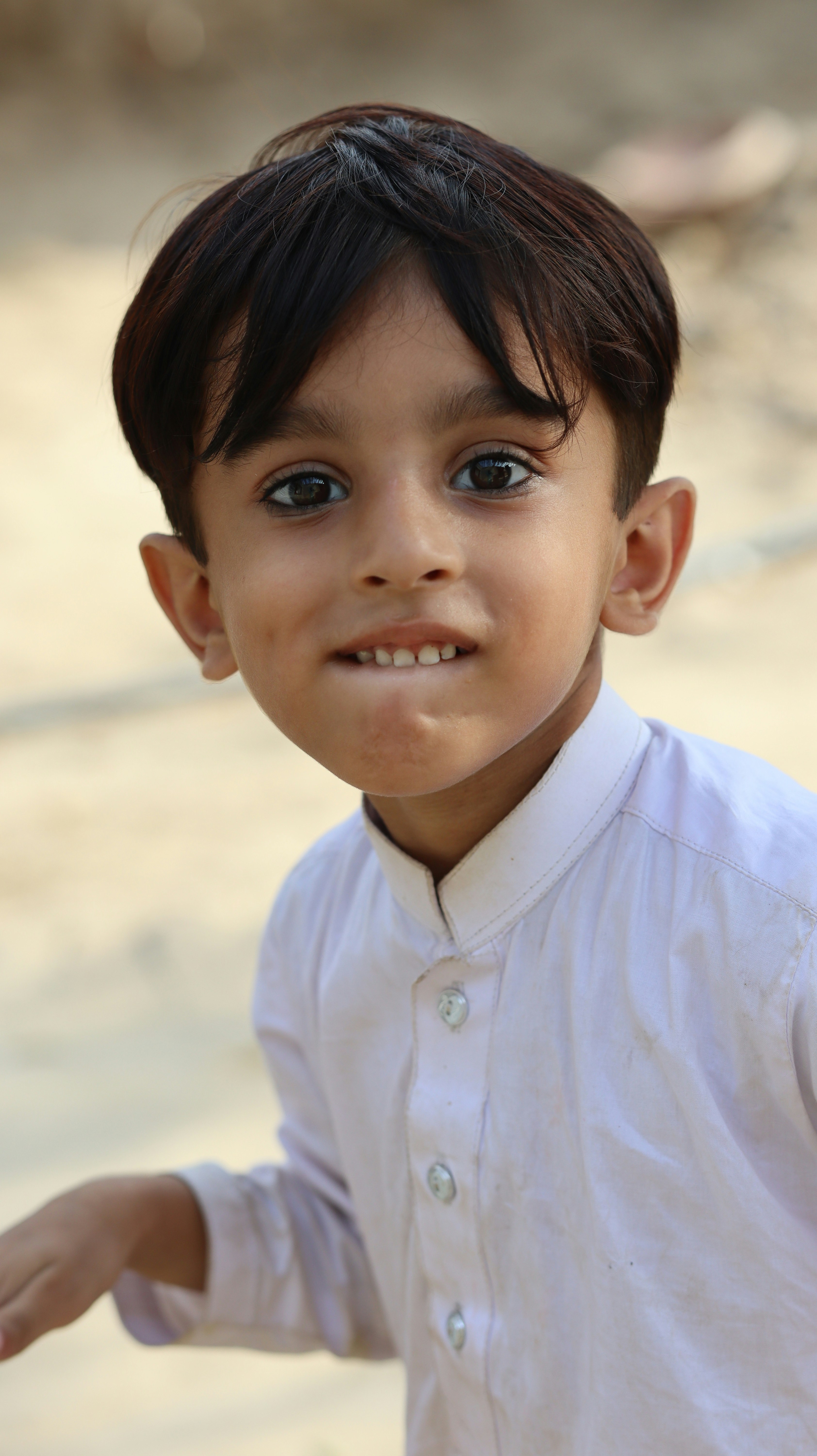 A young boy in a white shirt is smiling photo – Free Face Image on Unsplash
