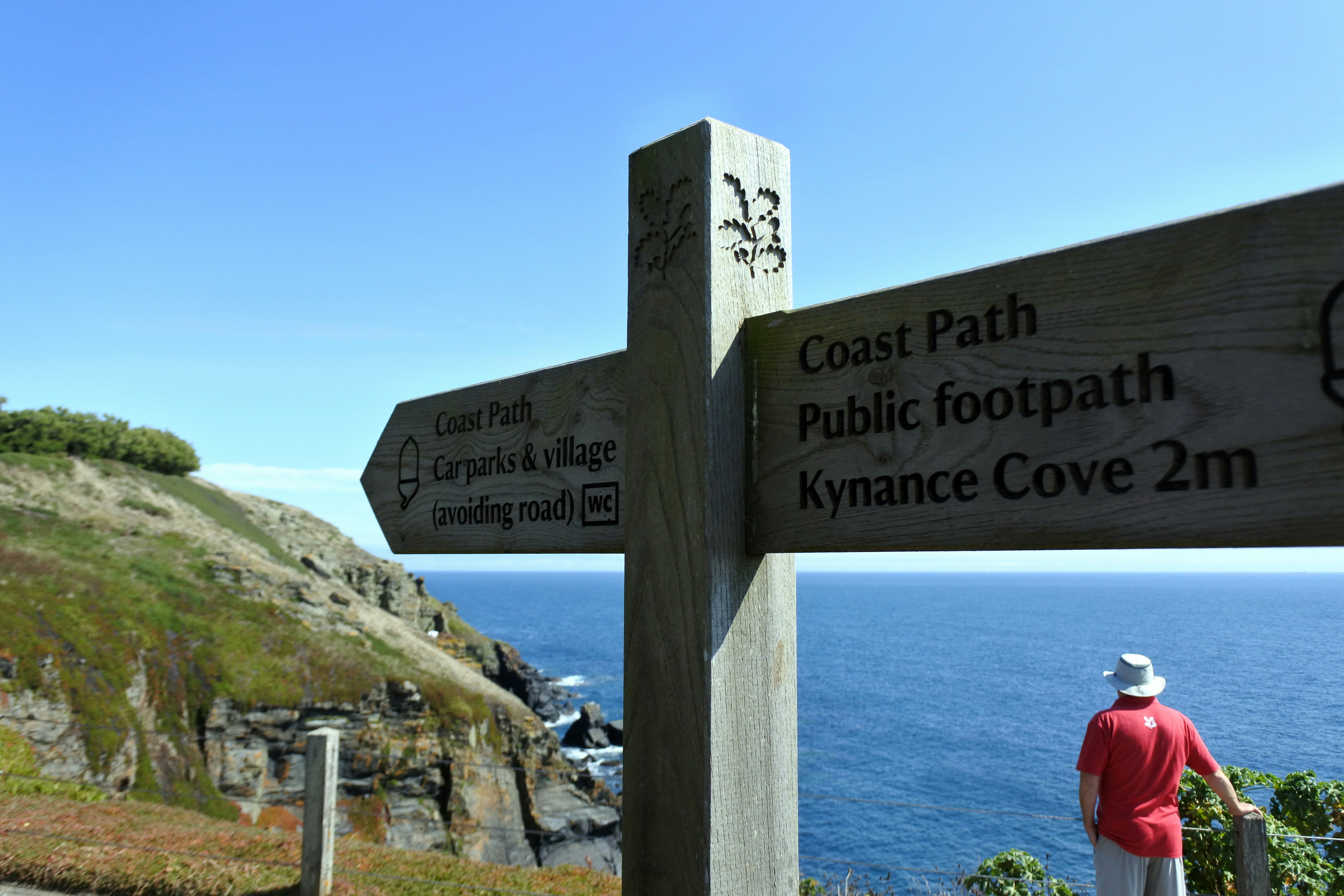Coastal Signpost at the Edge: A Cliffside Trail Framed by Sea and Sky