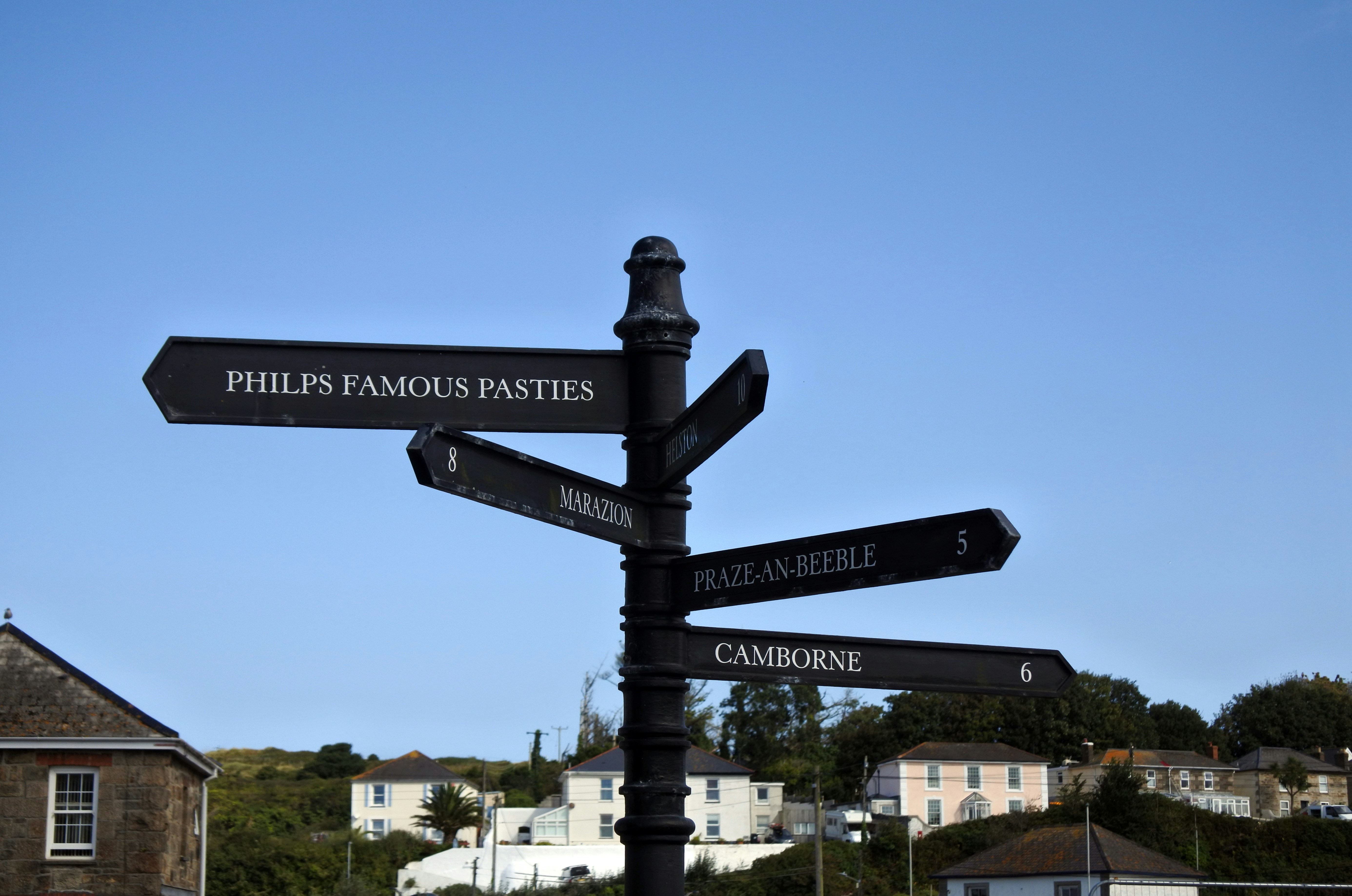 Crossroads at the Coast: A Seaside Signpost Points Toward Distant Streets