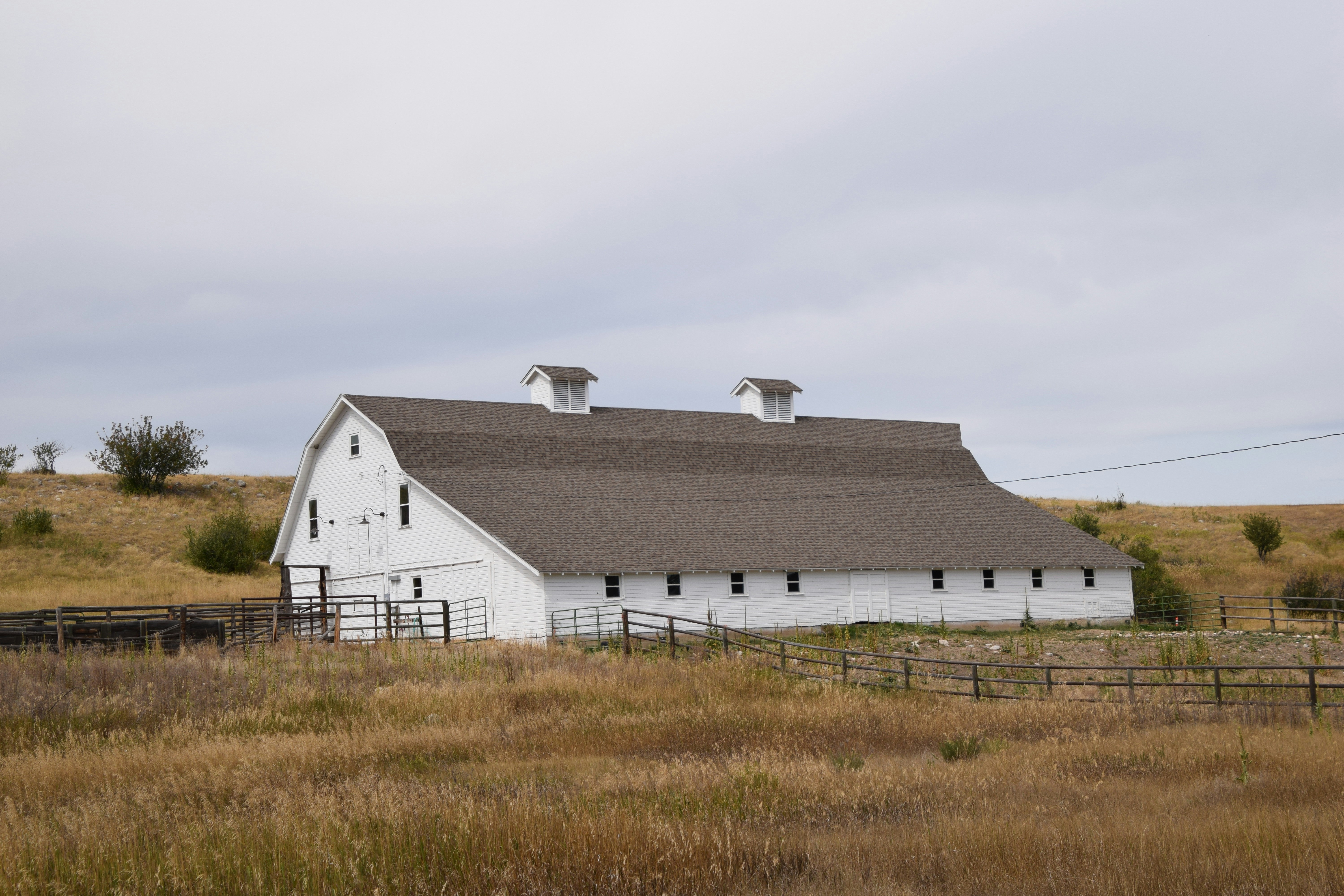 Old White Barn | A white barn with a black roof in a field