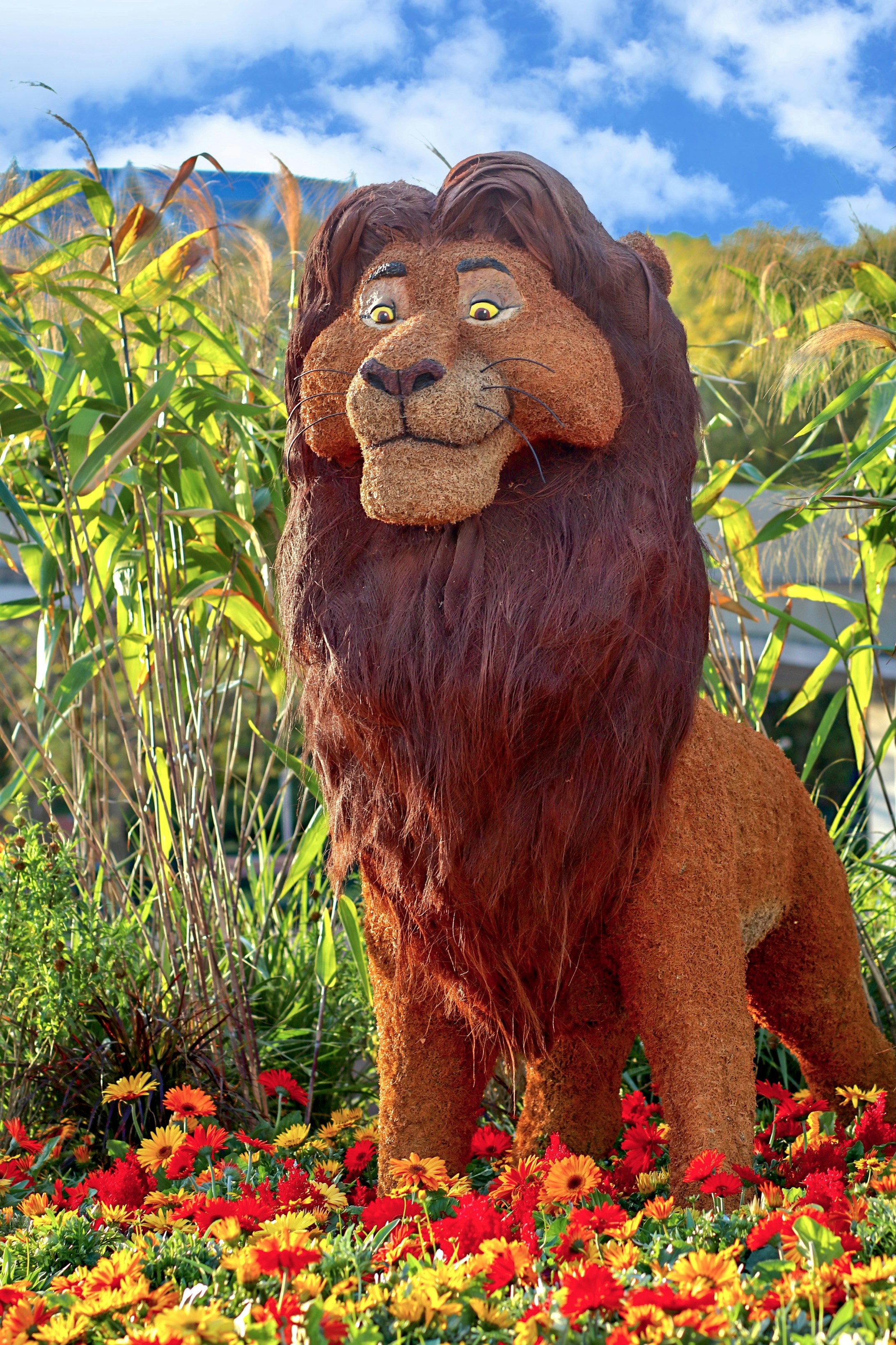 Garden Guardian: Felt-Lion Statue Stands Amid Colorful Annuals