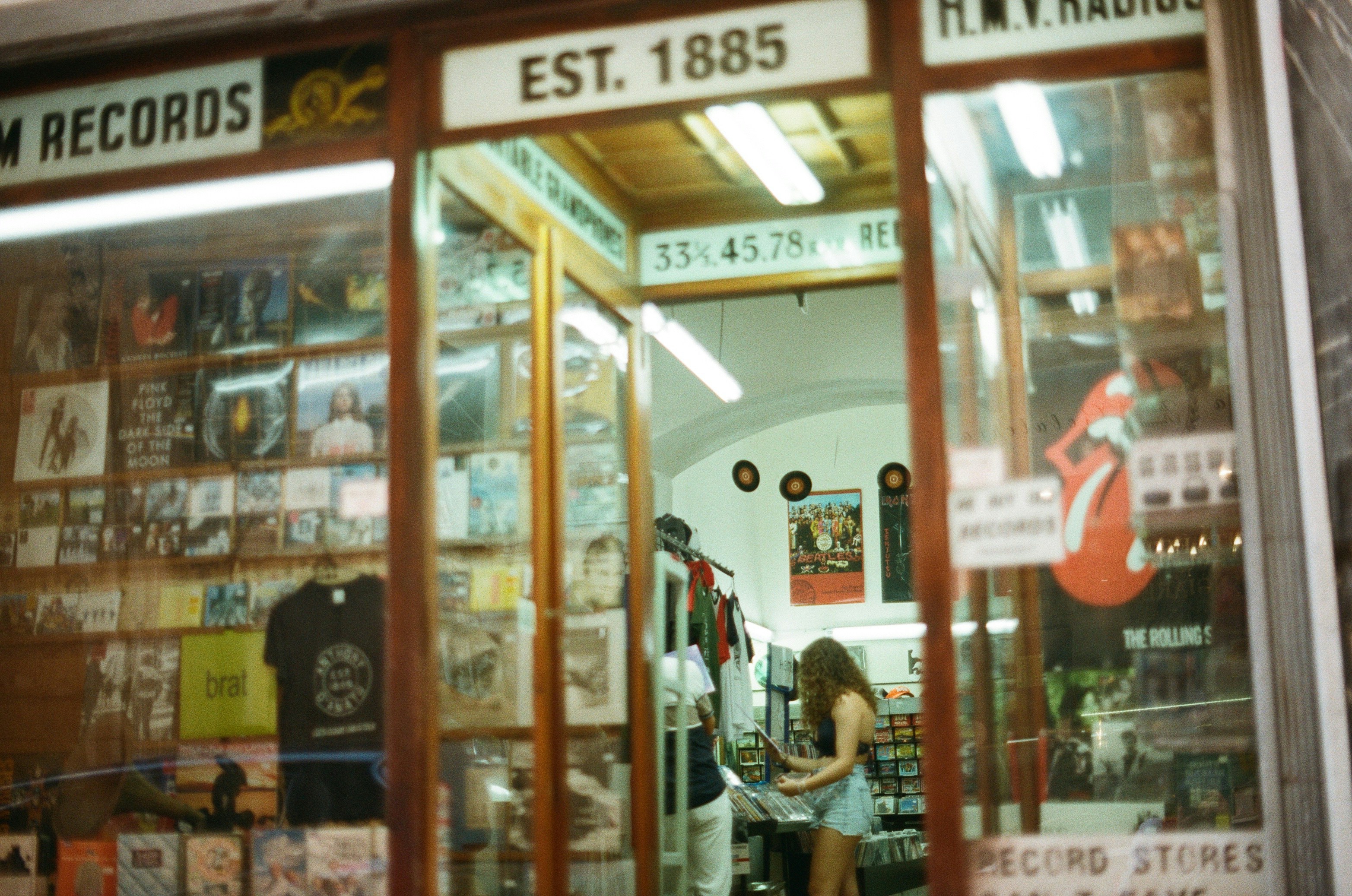 A woman sitting in the window of a record store photo – Free Book Image ...