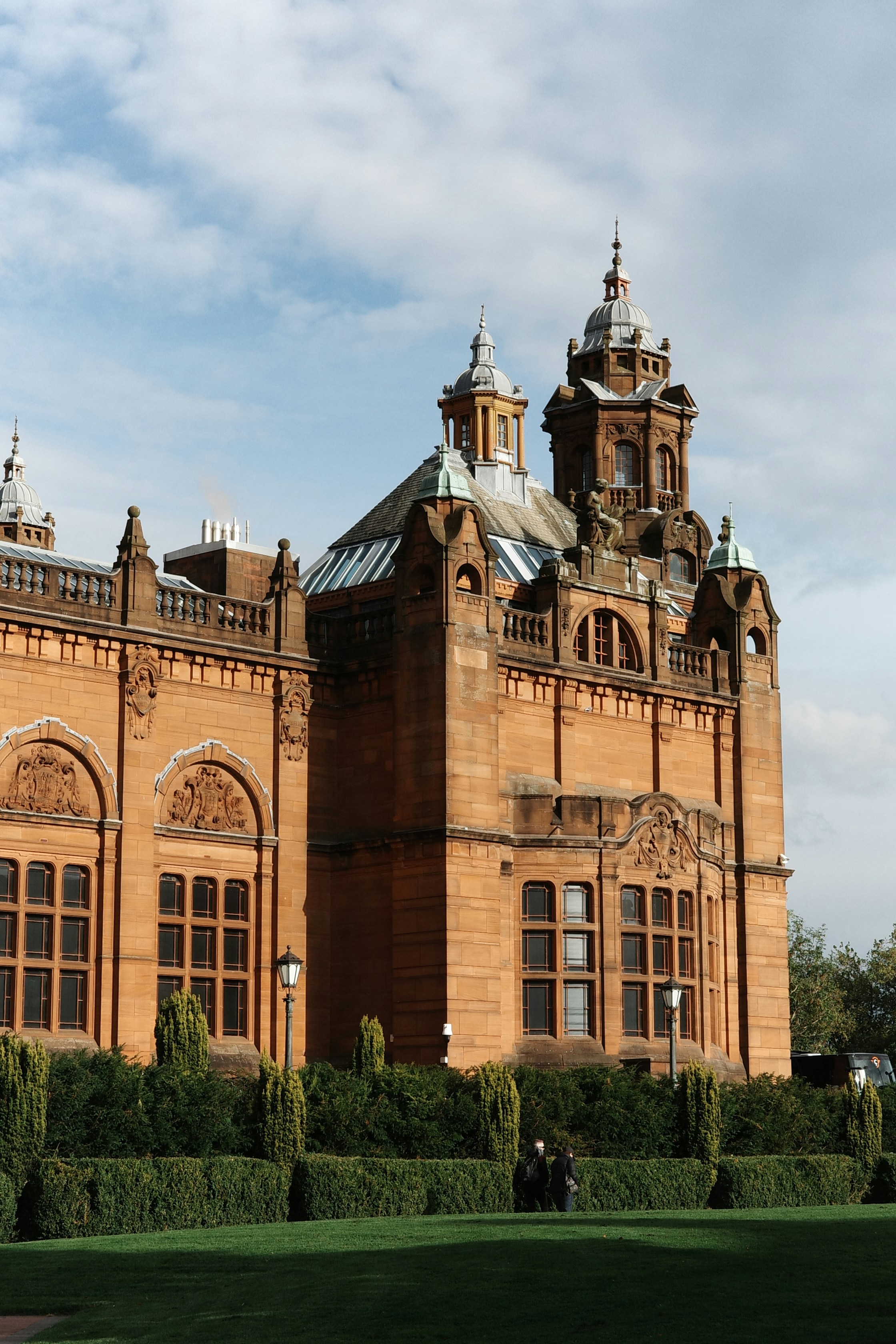 Red-brick Turrets Rise: A Historic Hall Framed by Trimmed Gardens