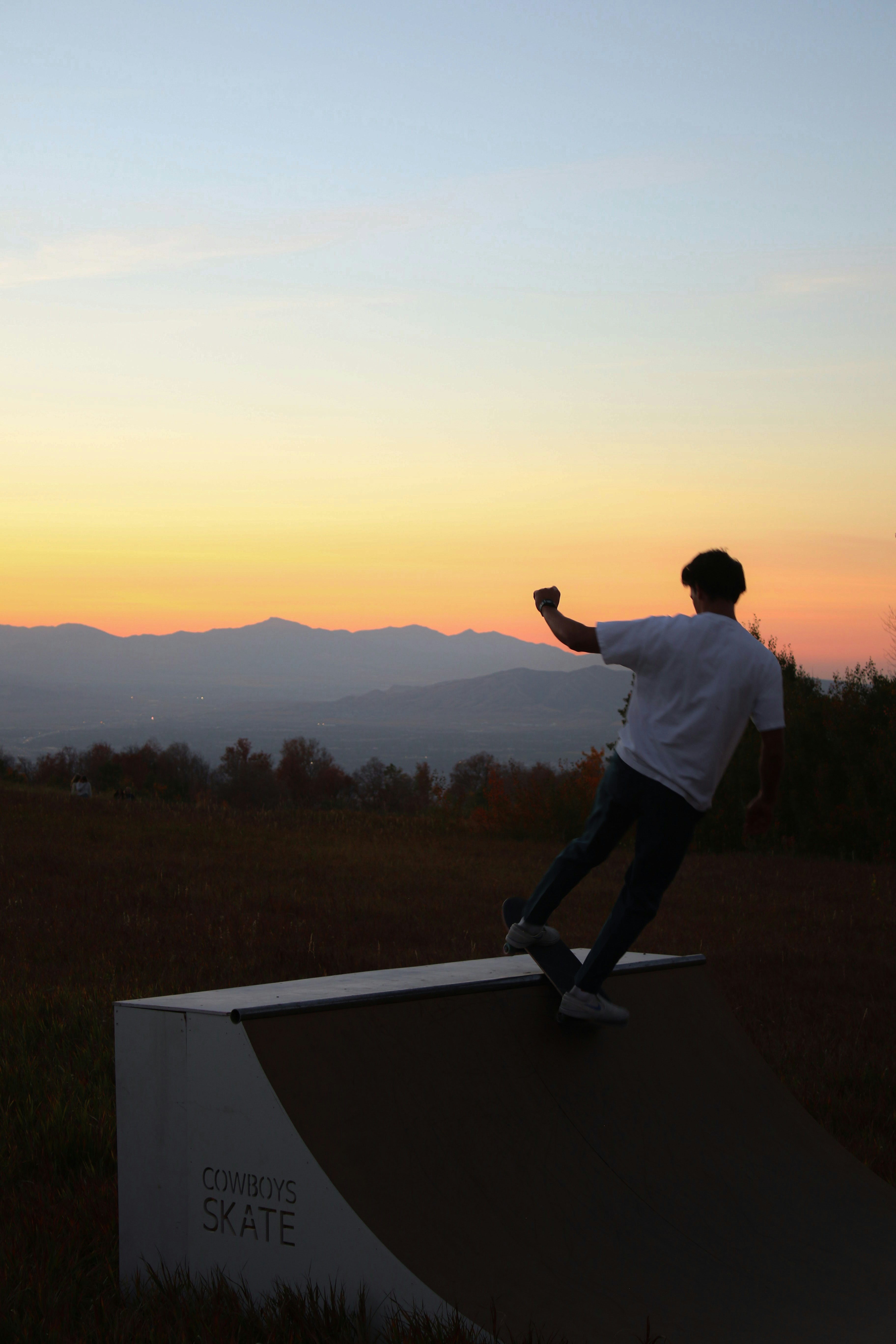 Edge of Sunset: Skater Balancing on the Ramp Against Quiet Hills