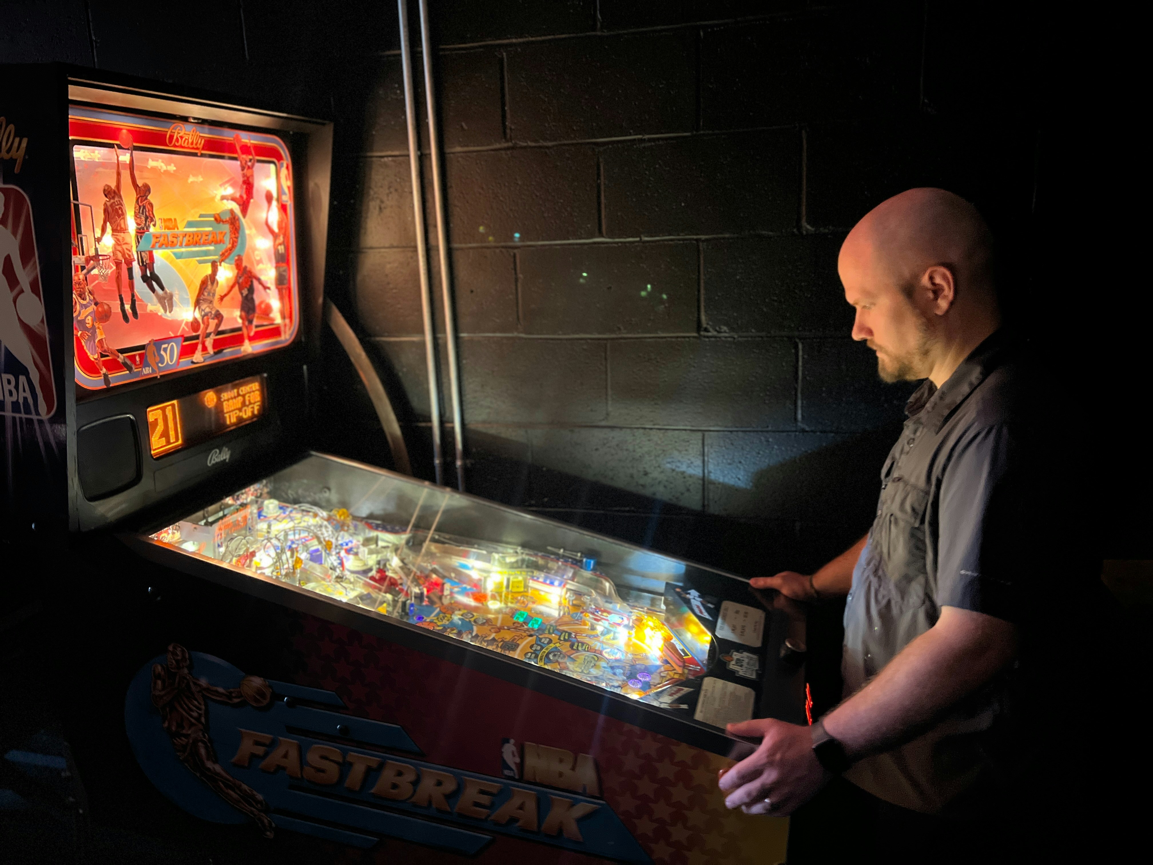 A man standing next to a pinball machine photo – Free Man Image on Unsplash