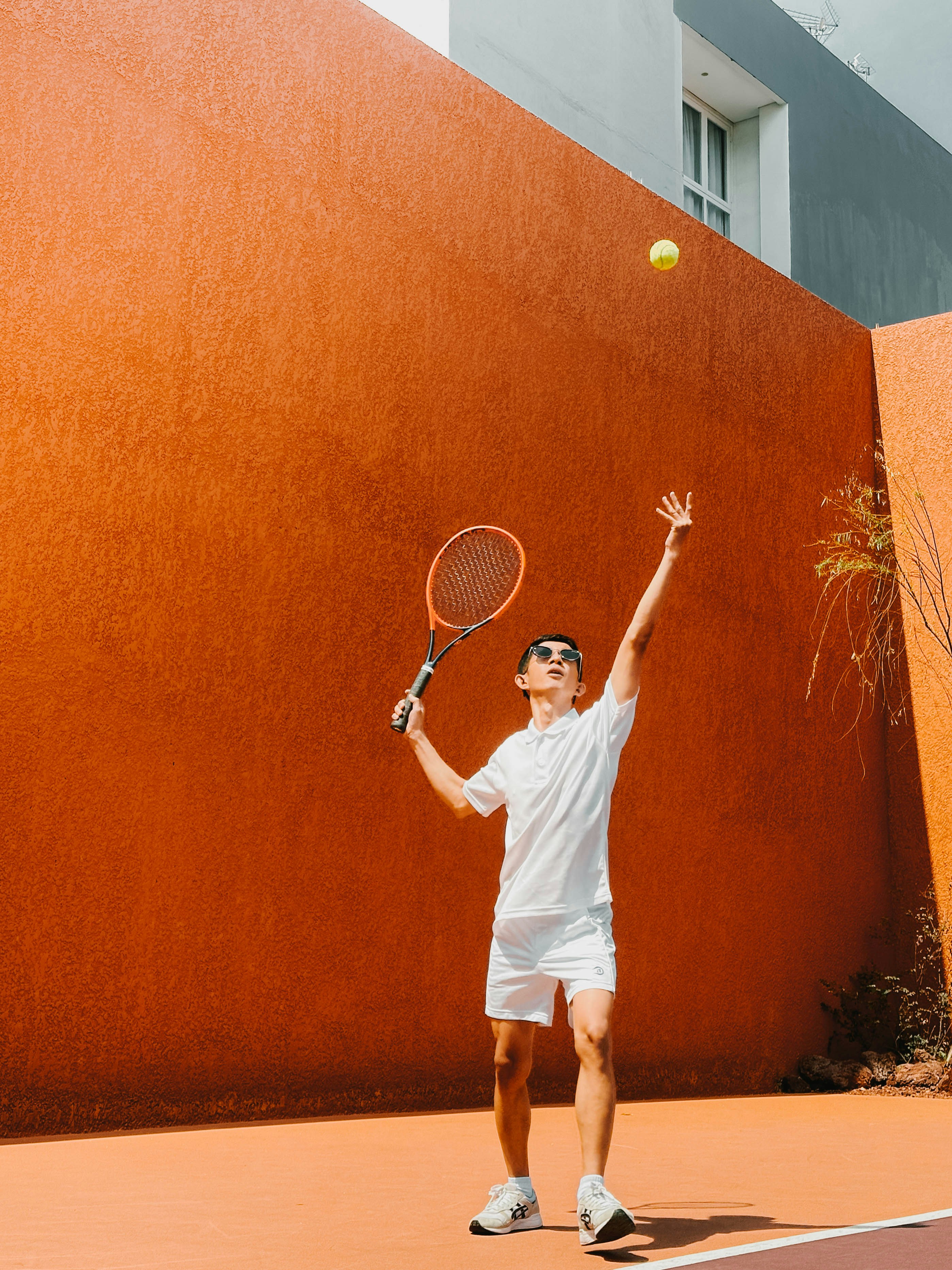 A man holding a tennis racquet on top of a tennis court photo – Free ...