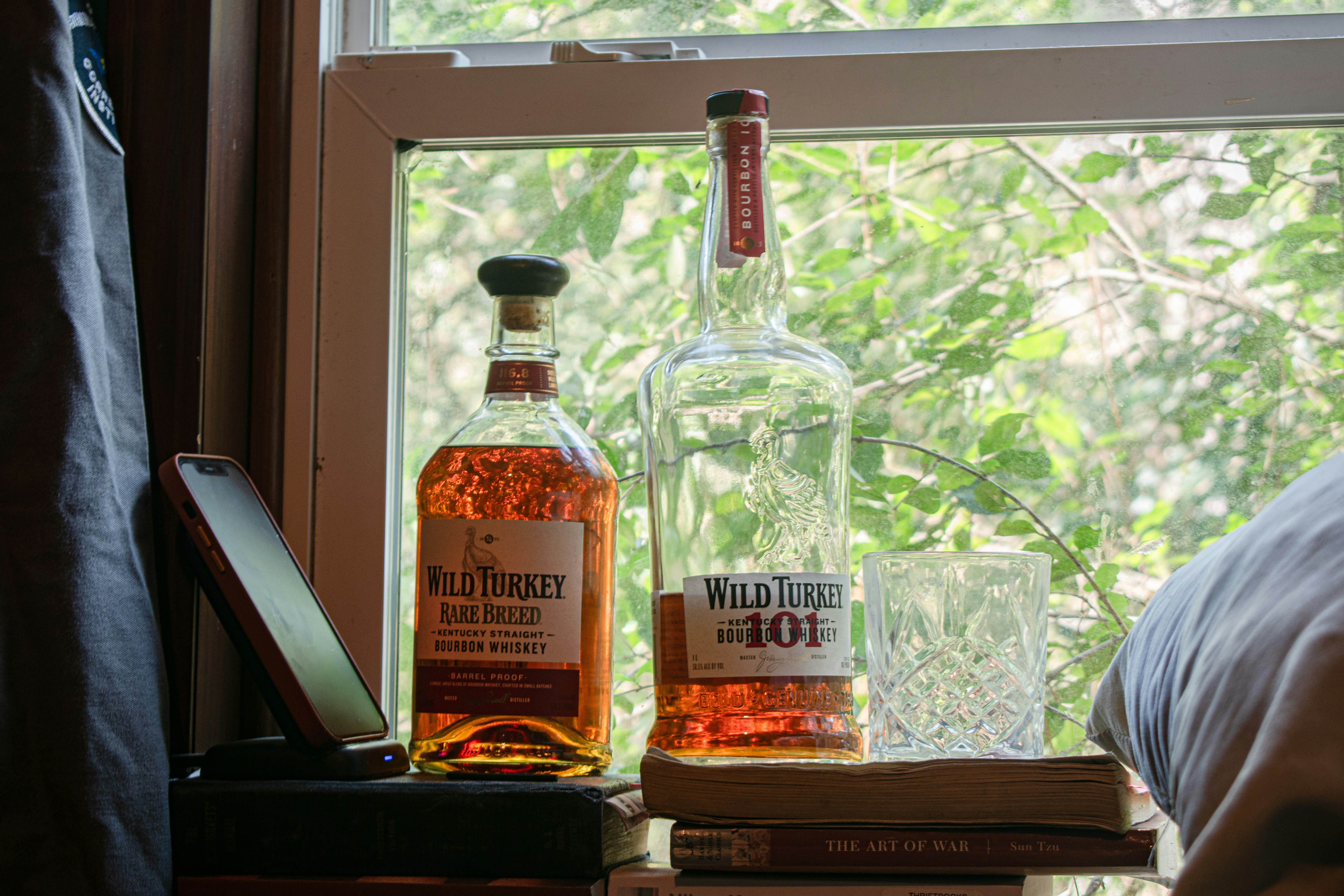 A bottle of whiskey sitting next to a window photo – Free Window Image ...