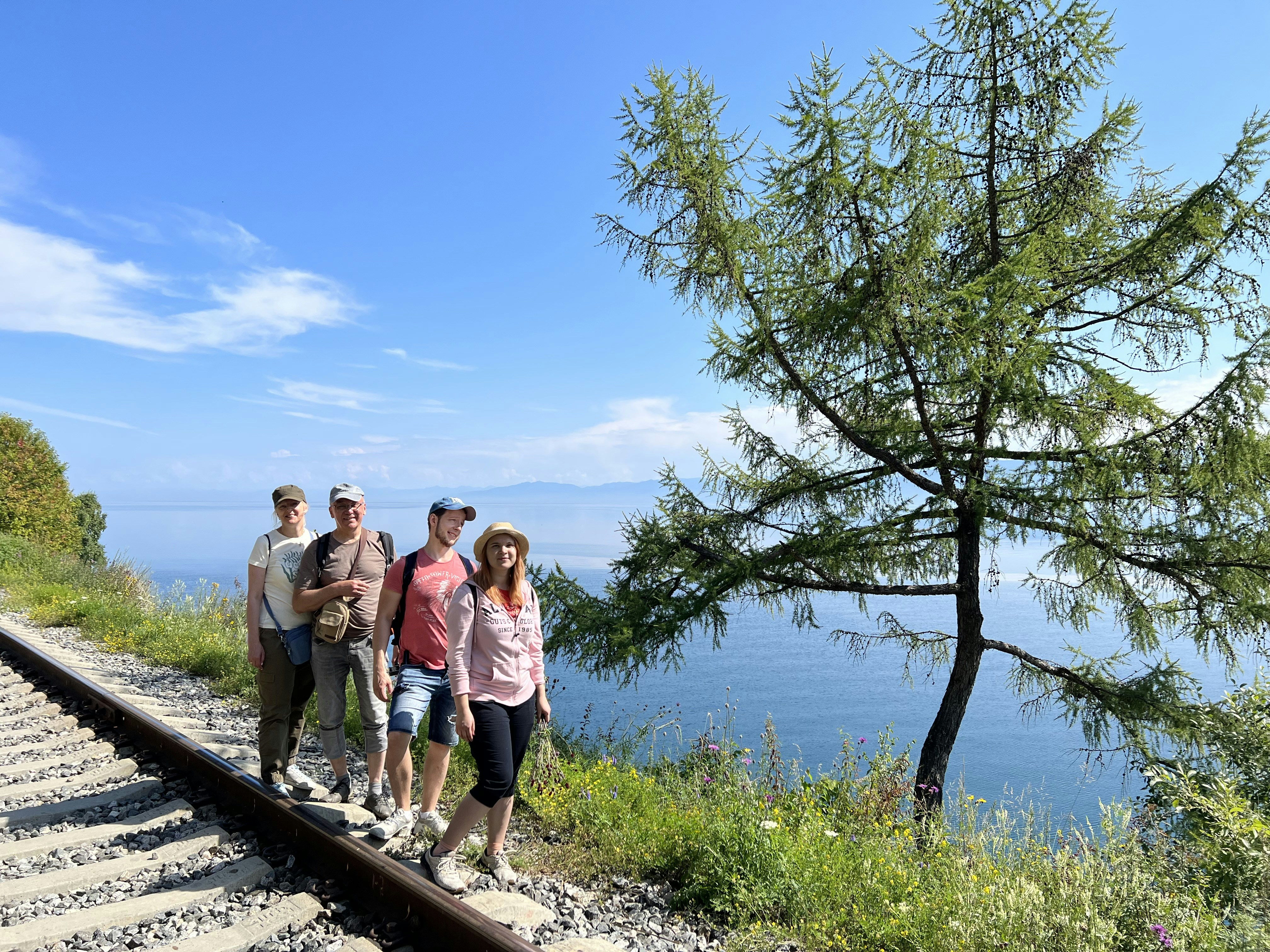 Lakeside Rails: Four Friends on a Sunlit Track