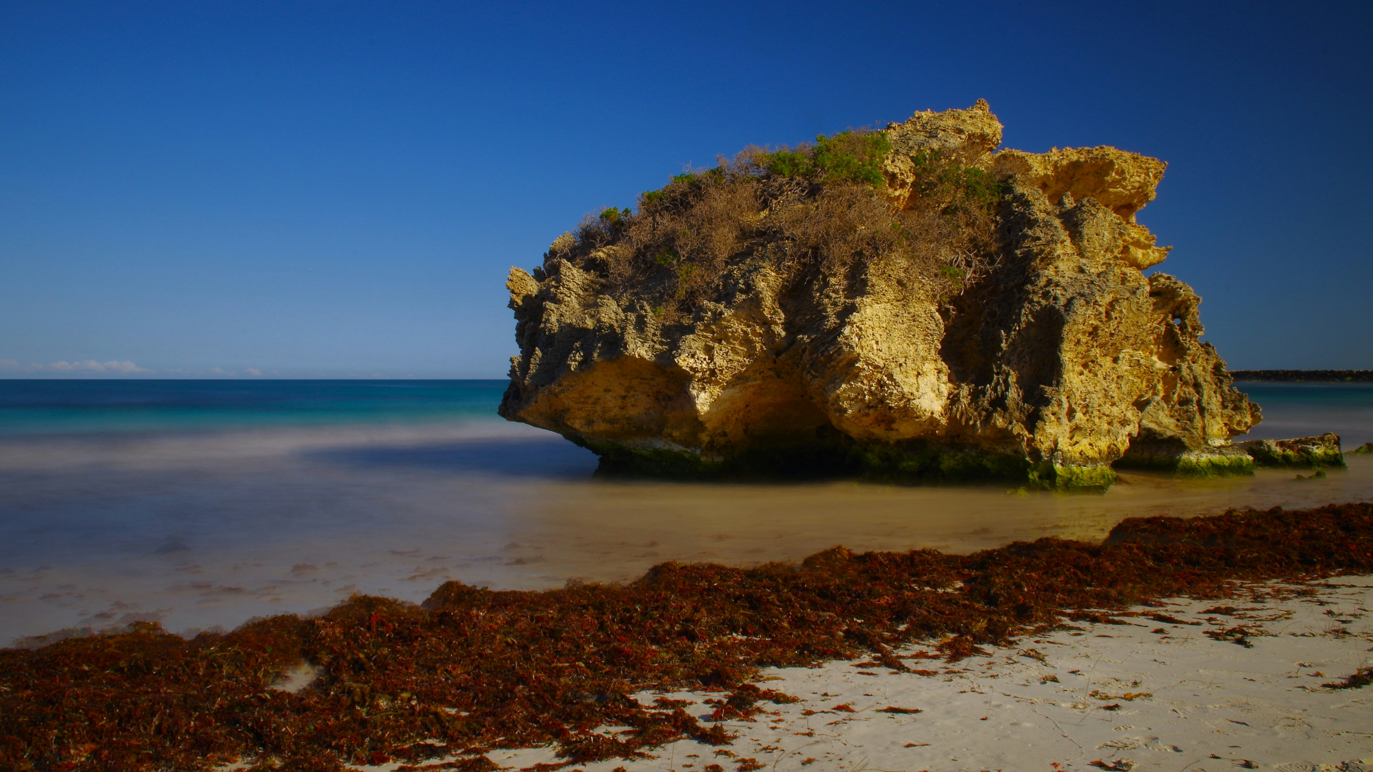 A large rock sitting on top of a sandy beach photo – Free Two rocks wa ...