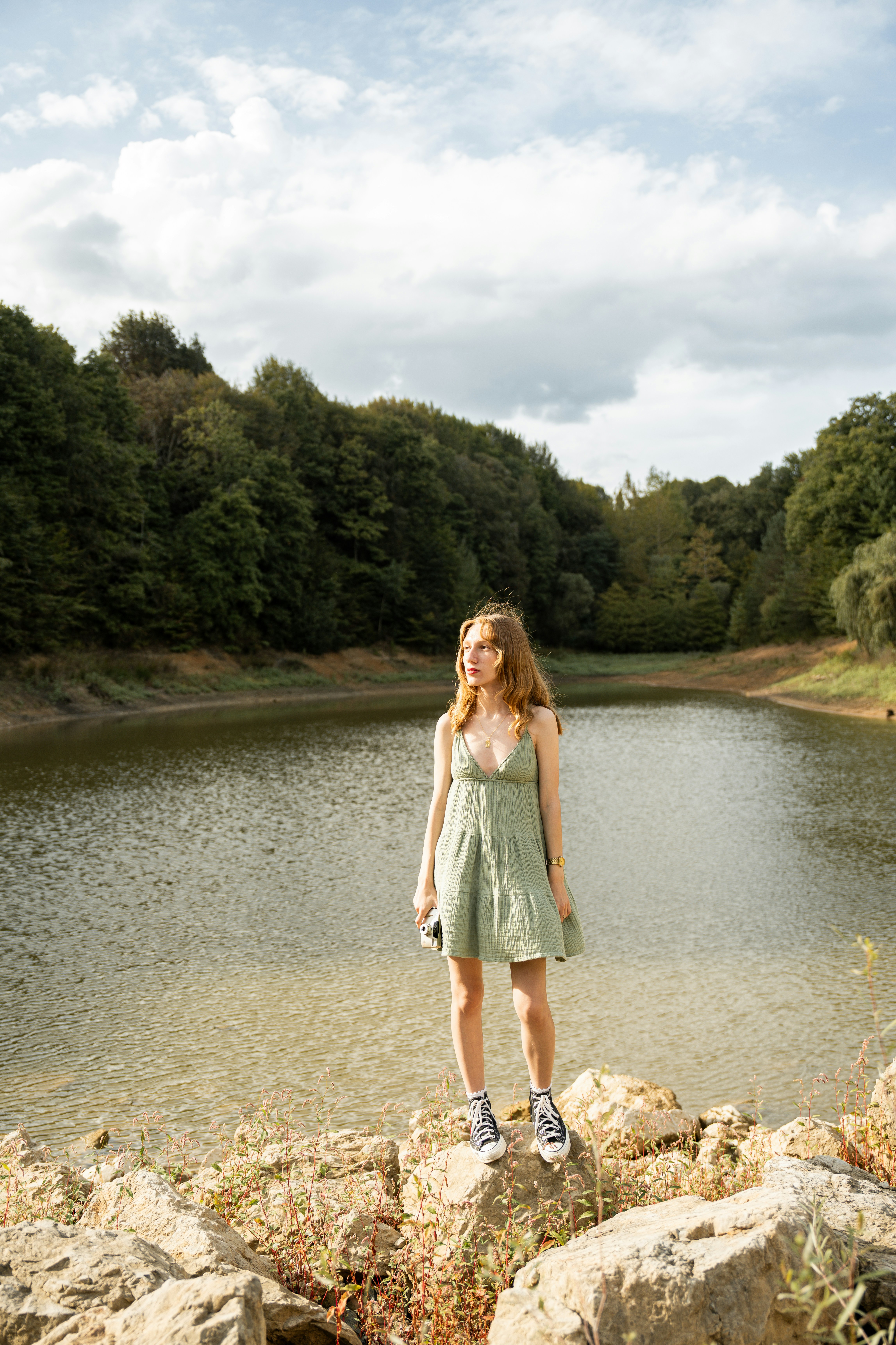 Una mujer de pie sobre las rocas cerca de un lago foto – Imagen de ...