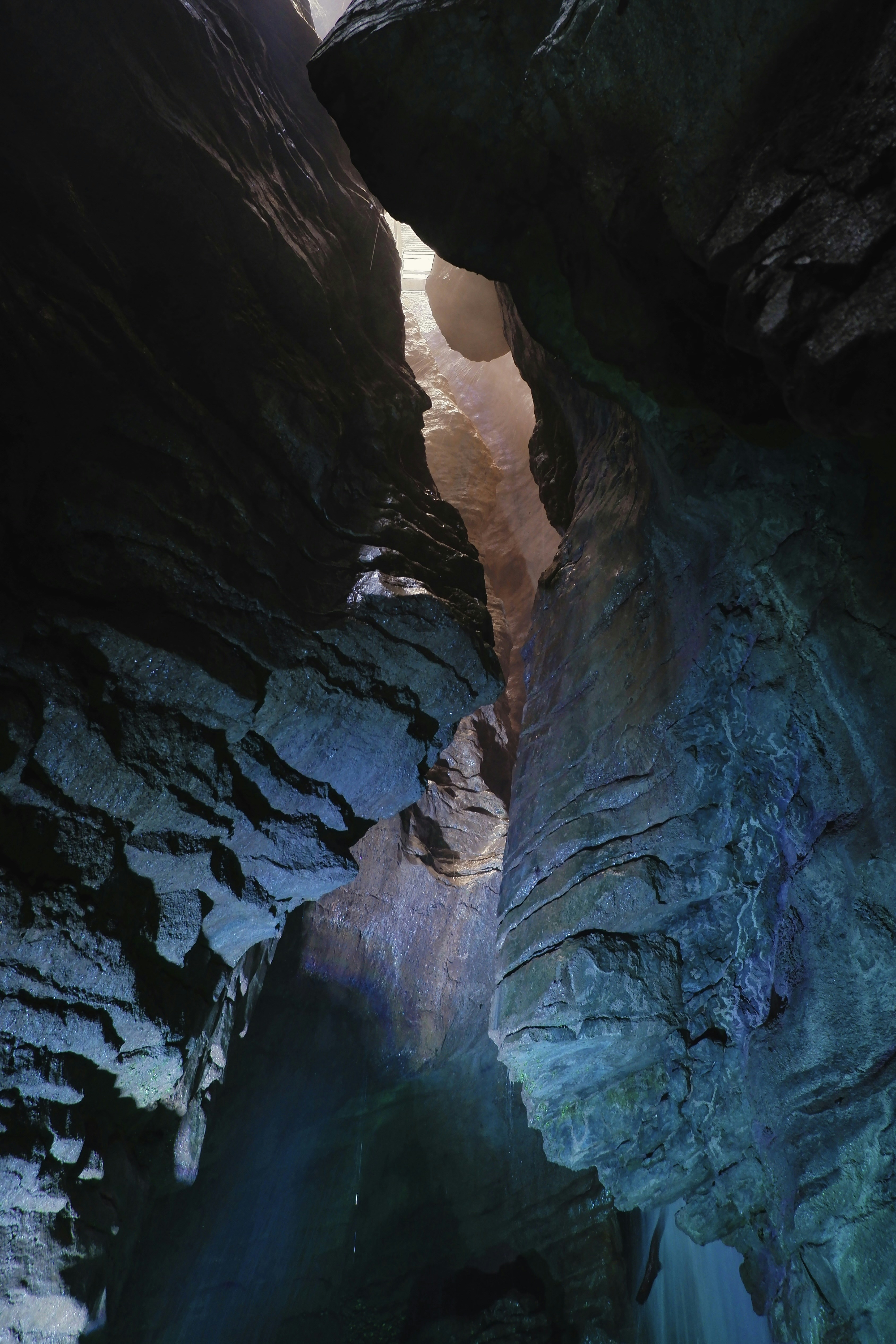 A narrow canyon with a narrow opening in the middle photo – Free Cave ...