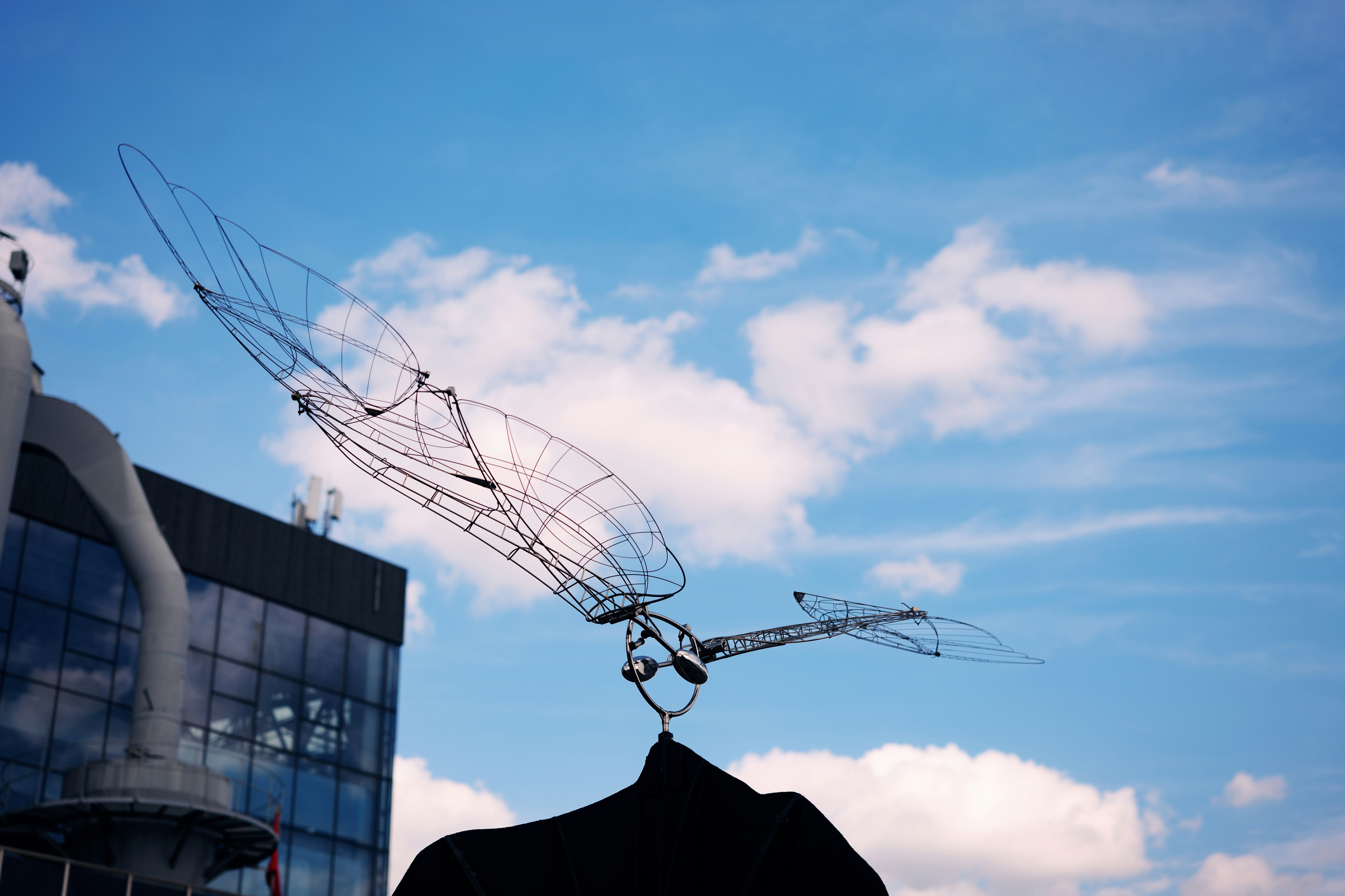 The Wire-Wing Apparatus Soaring over a Modern Facade