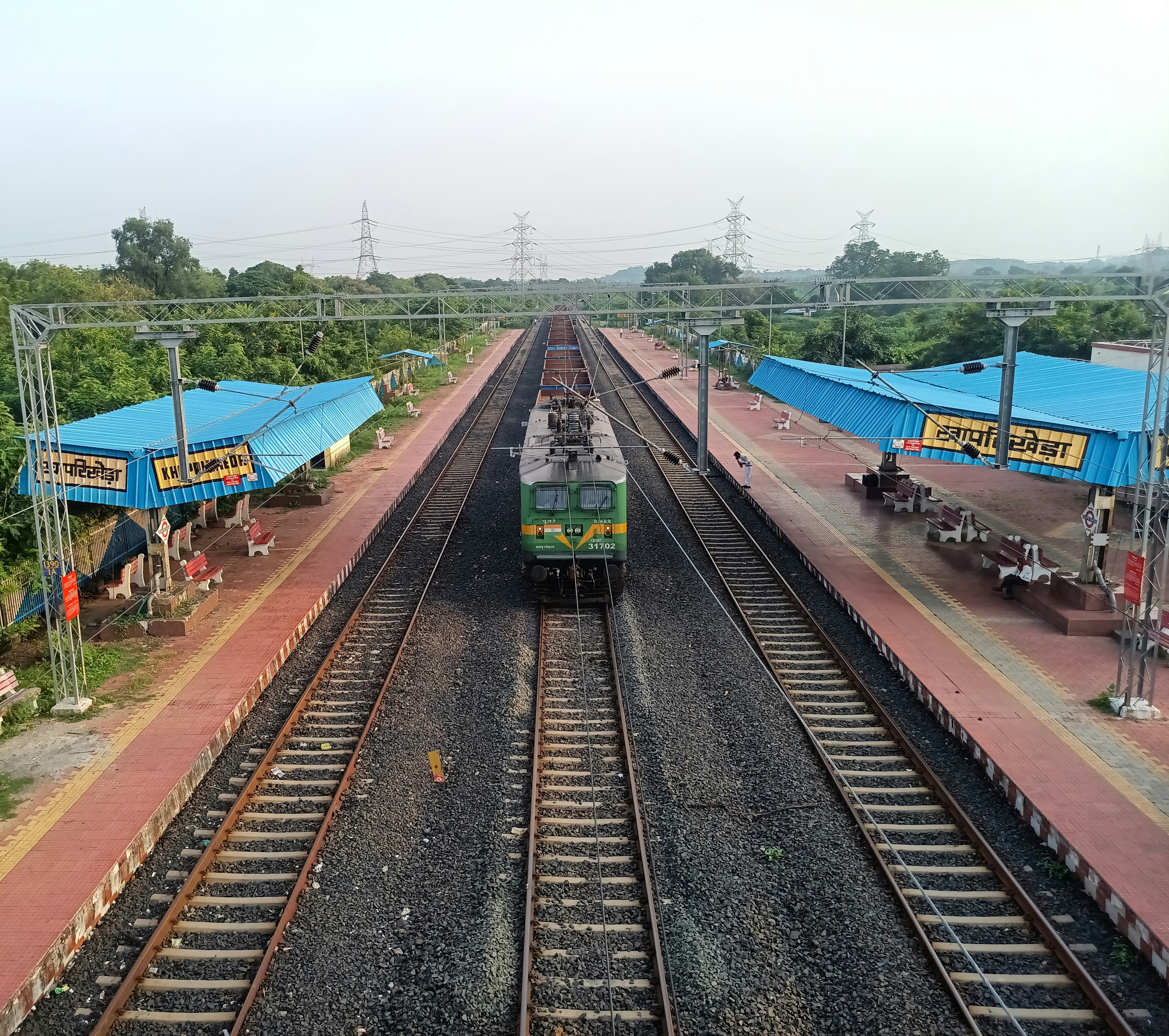 A train traveling down train tracks next to a train station photo ...