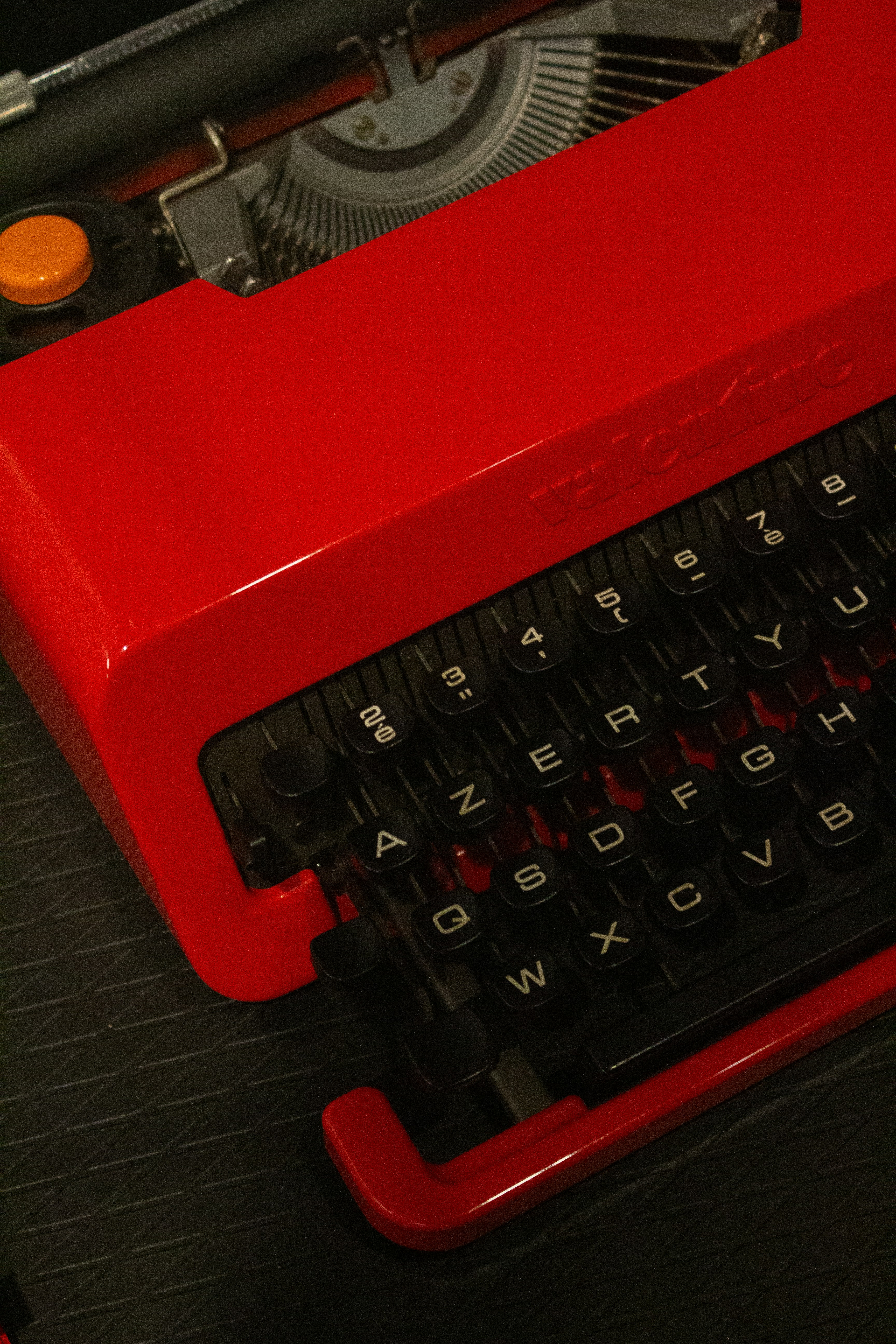 Crimson Close-Up: A Vintage Typewriter's Bold Red Form on a Textured Desk