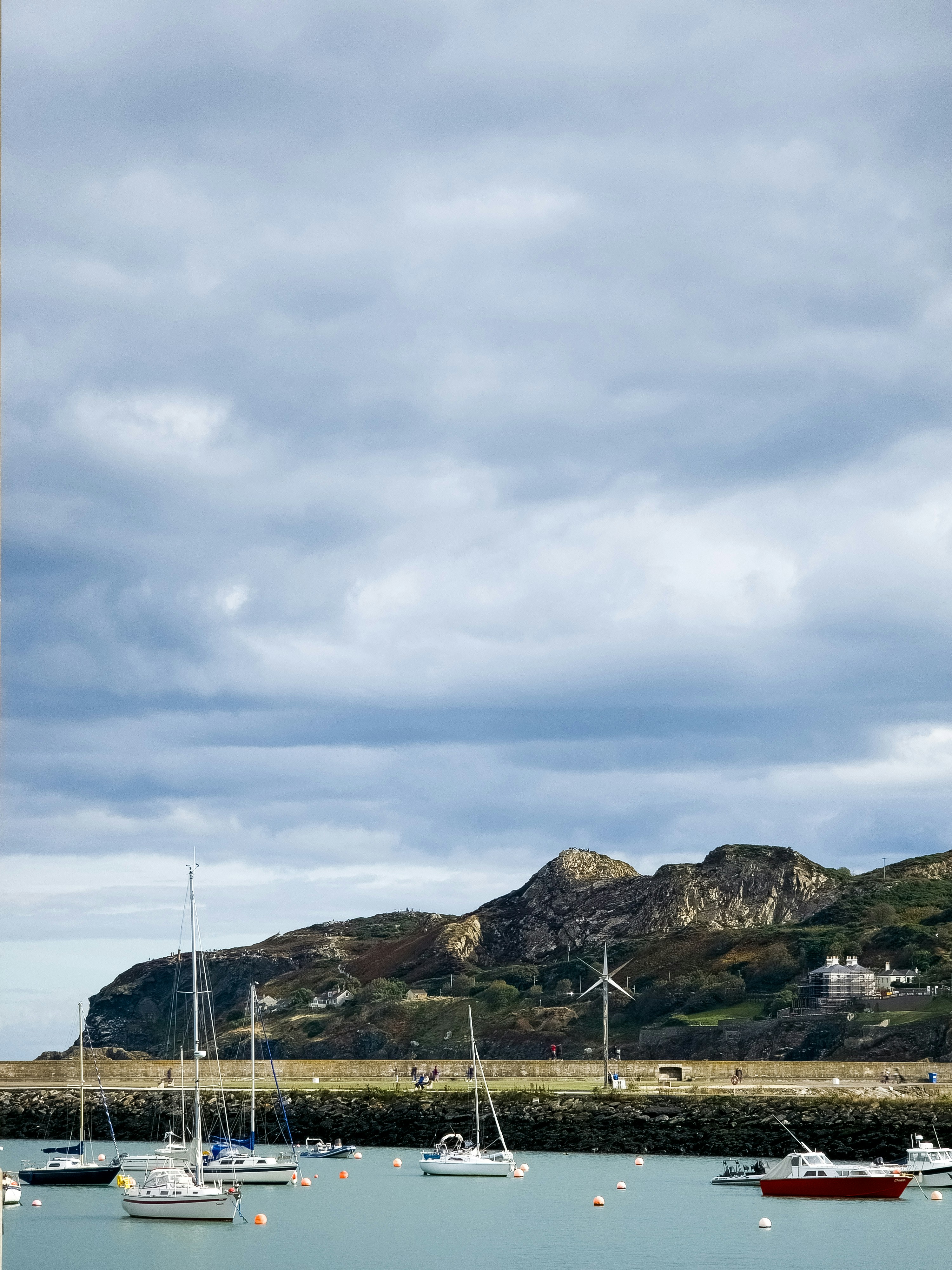 Harbor Quiet: Sails, Rocks, and a Shrouded Sky