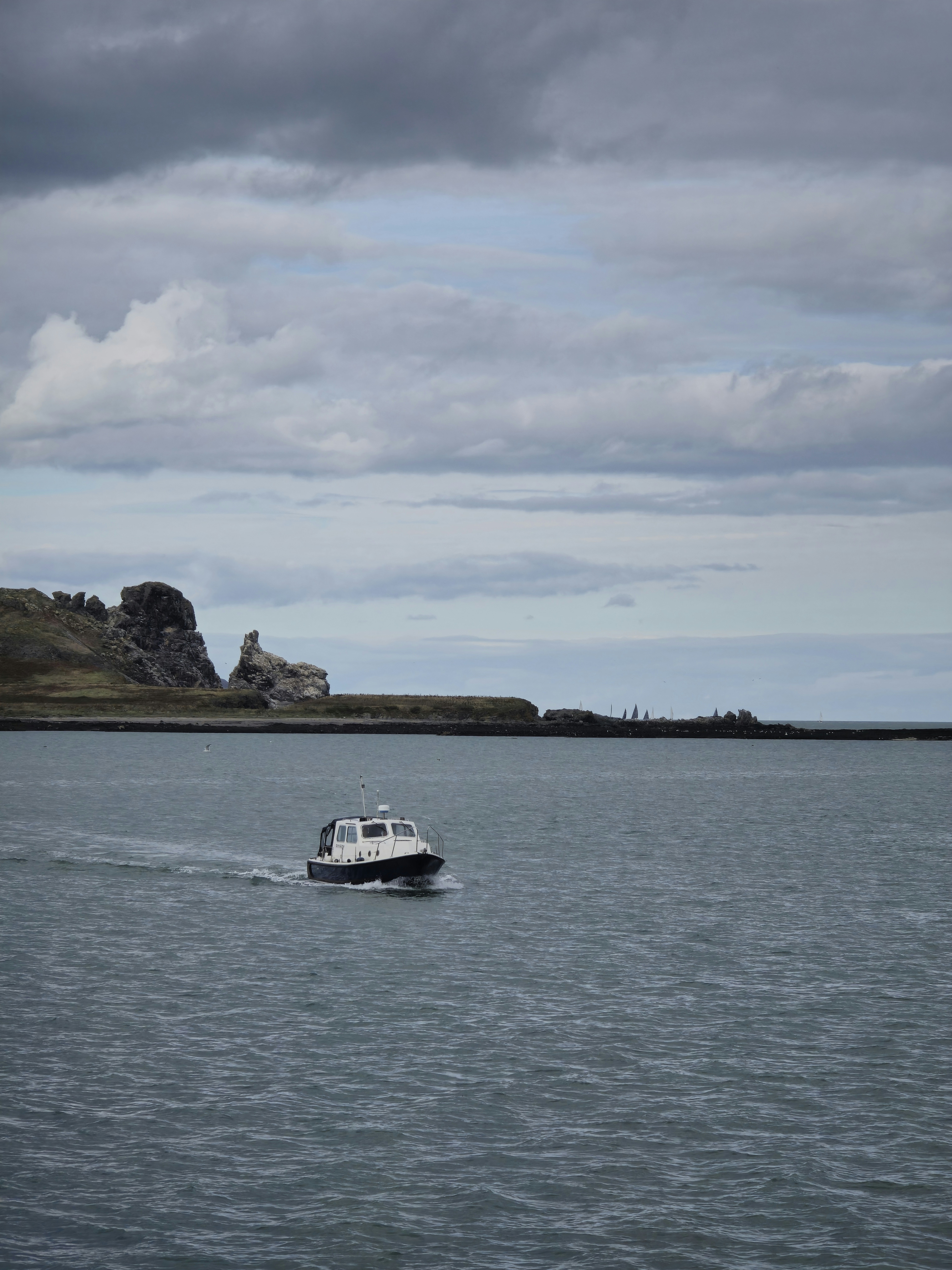 Harbor Glide: A lone motorboat under overcast skies