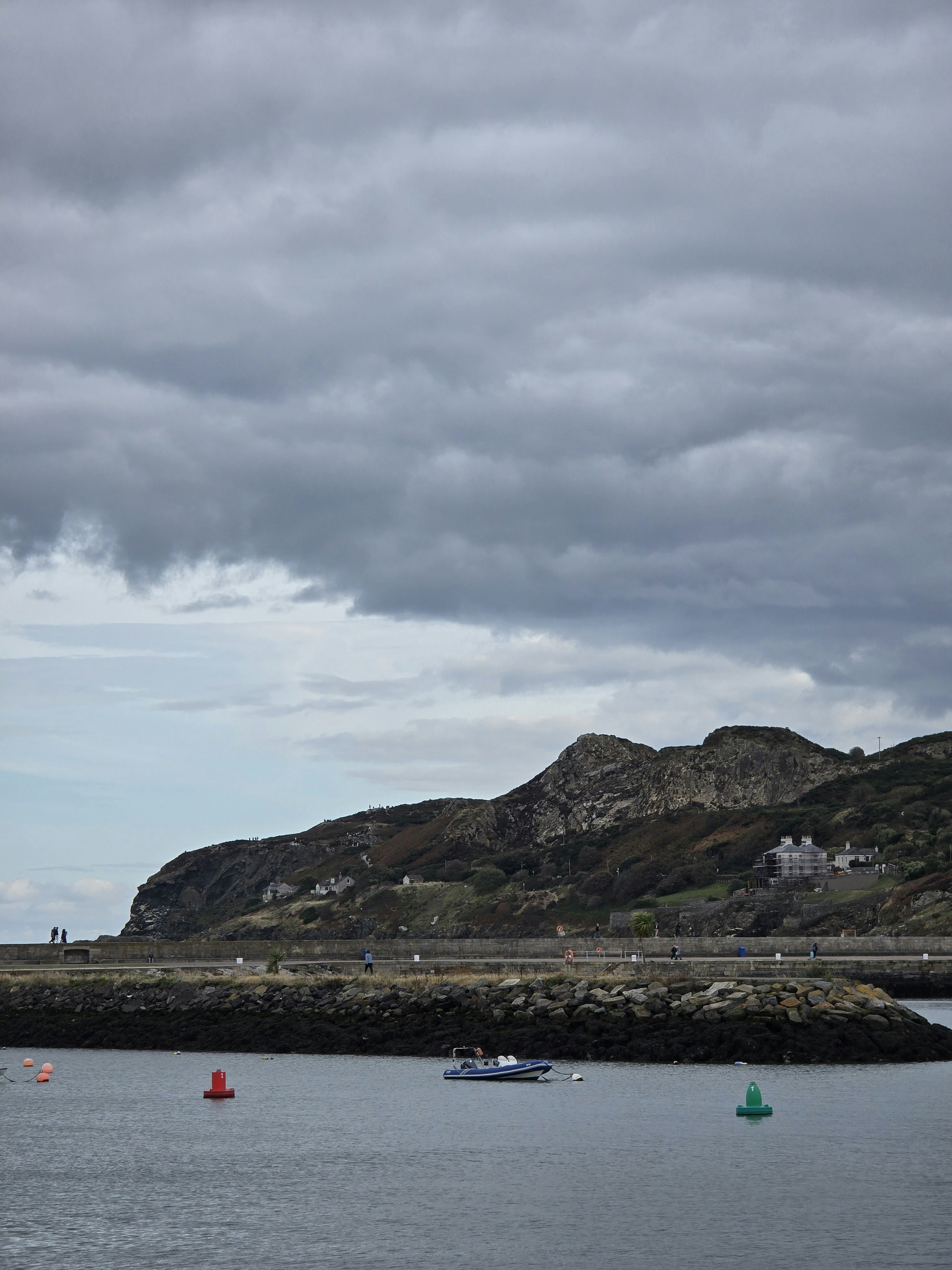 Blue Boat in a Quiet Cove Beneath Slate Skies