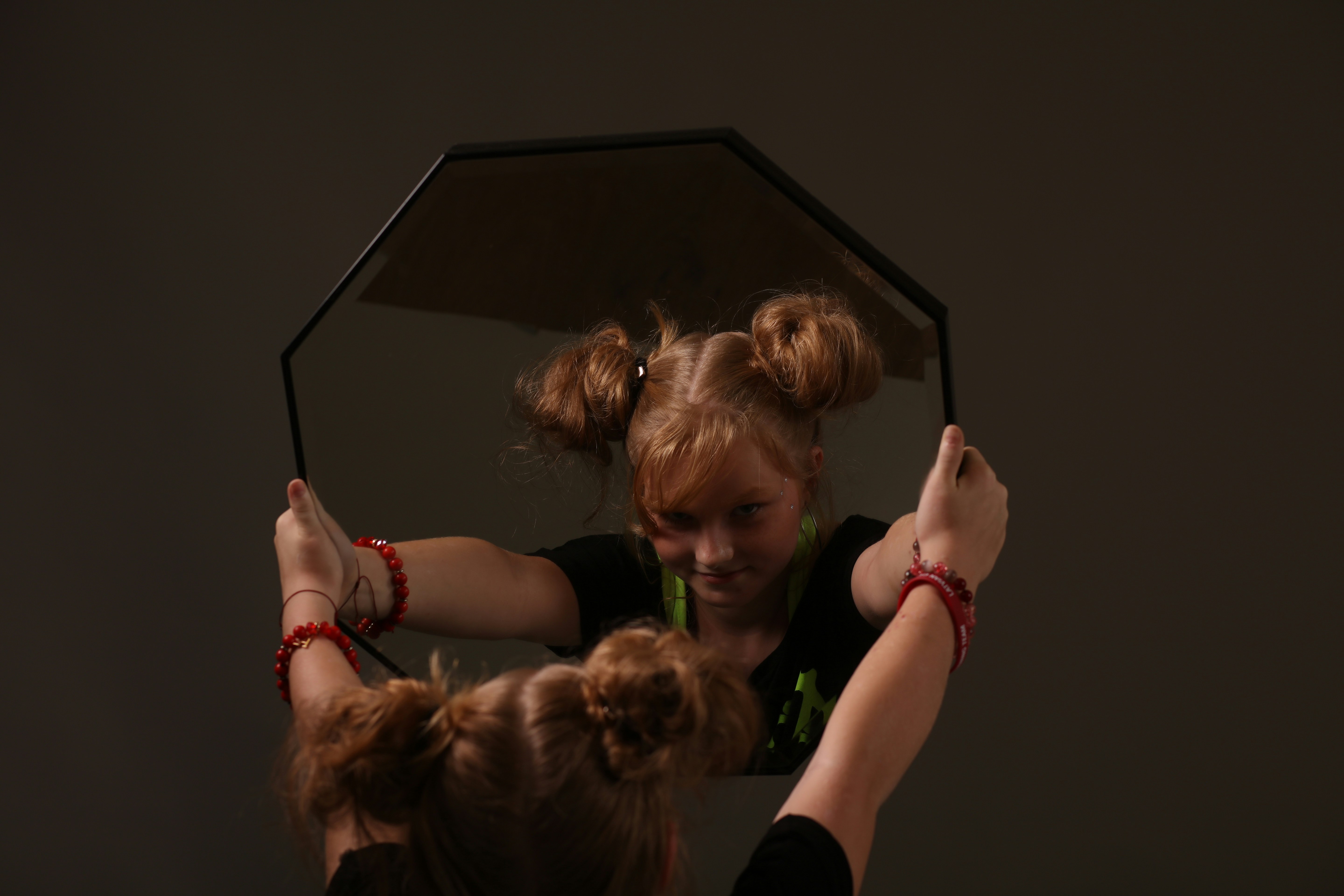 Hexagonal Echo: A handheld hexagonal-mirror portrait of a girl with twin buns