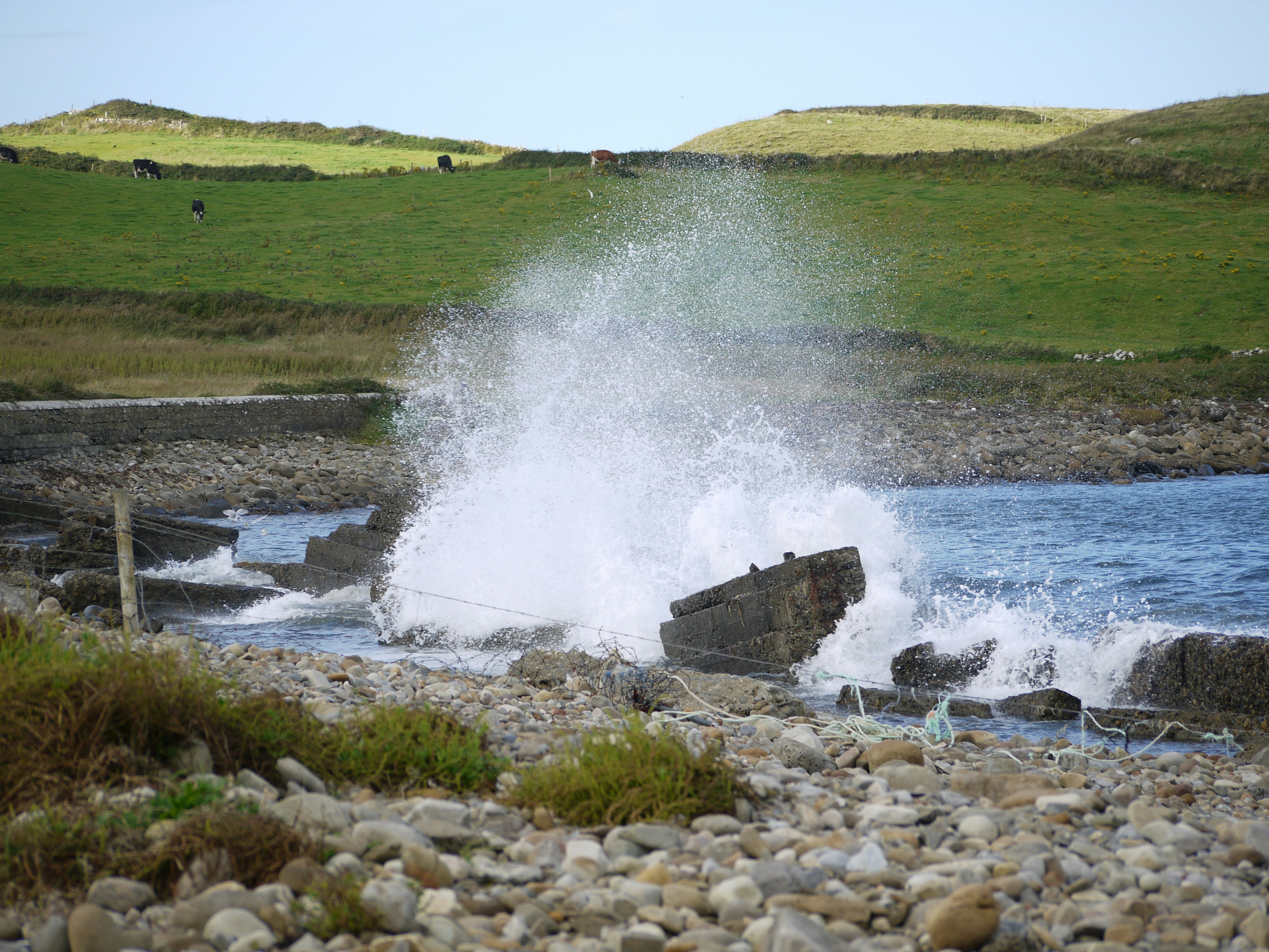 A large wave crashing onto a rocky shore
