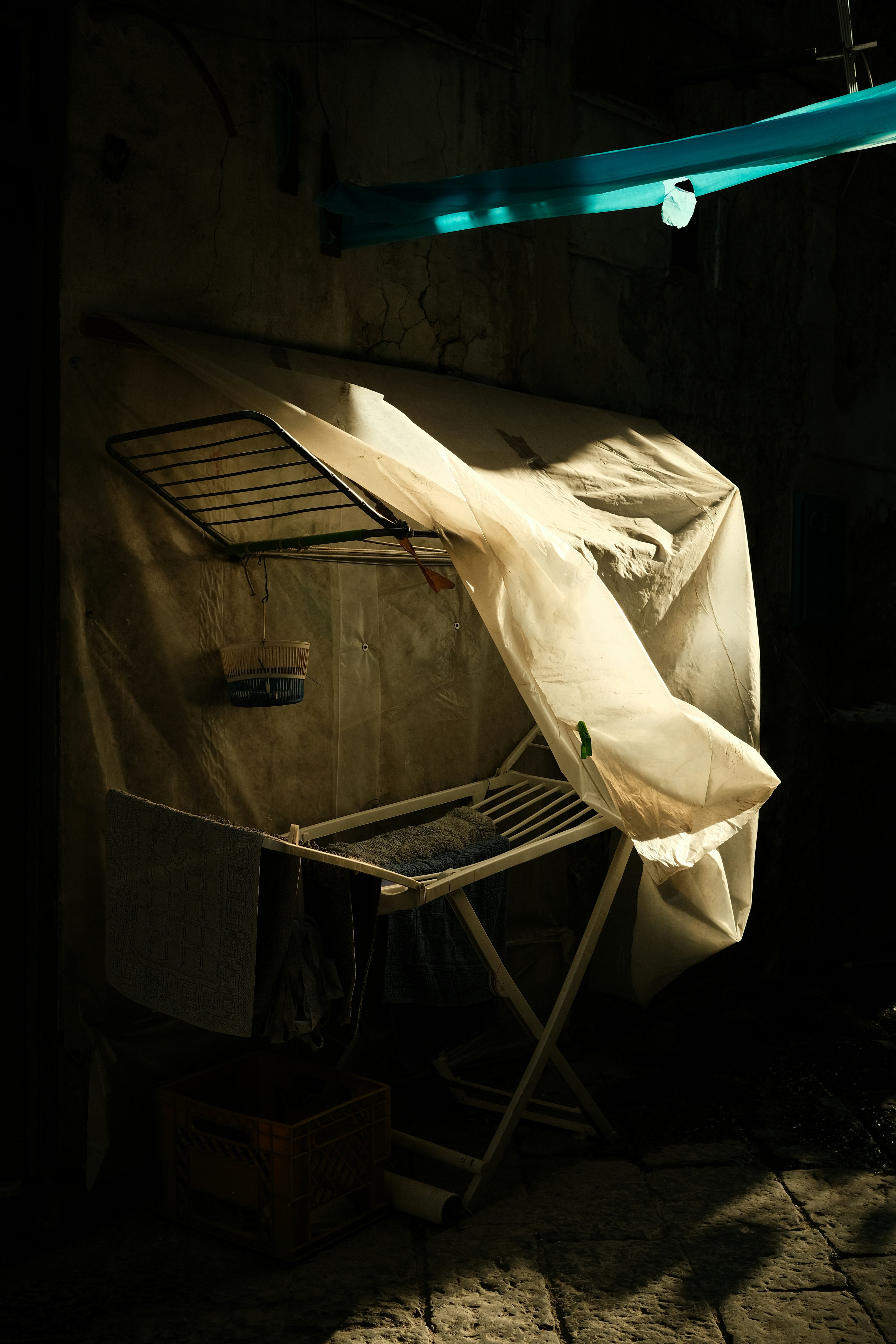 Illuminated Veil: a Makeshift Laundry Shelter in a Shadowed Alley
