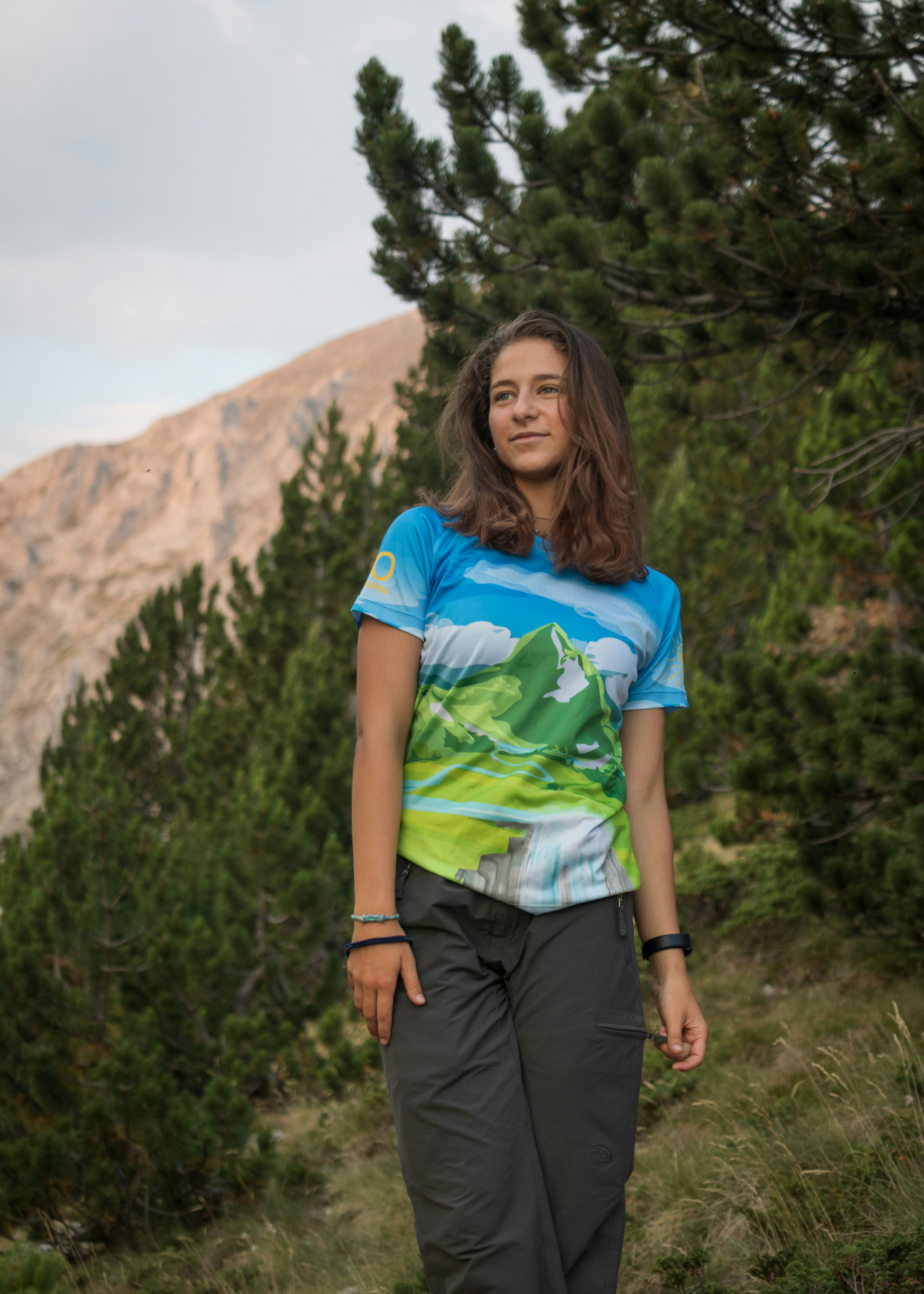A woman standing on top of a grass covered hillside photo – Free Sleeve ...