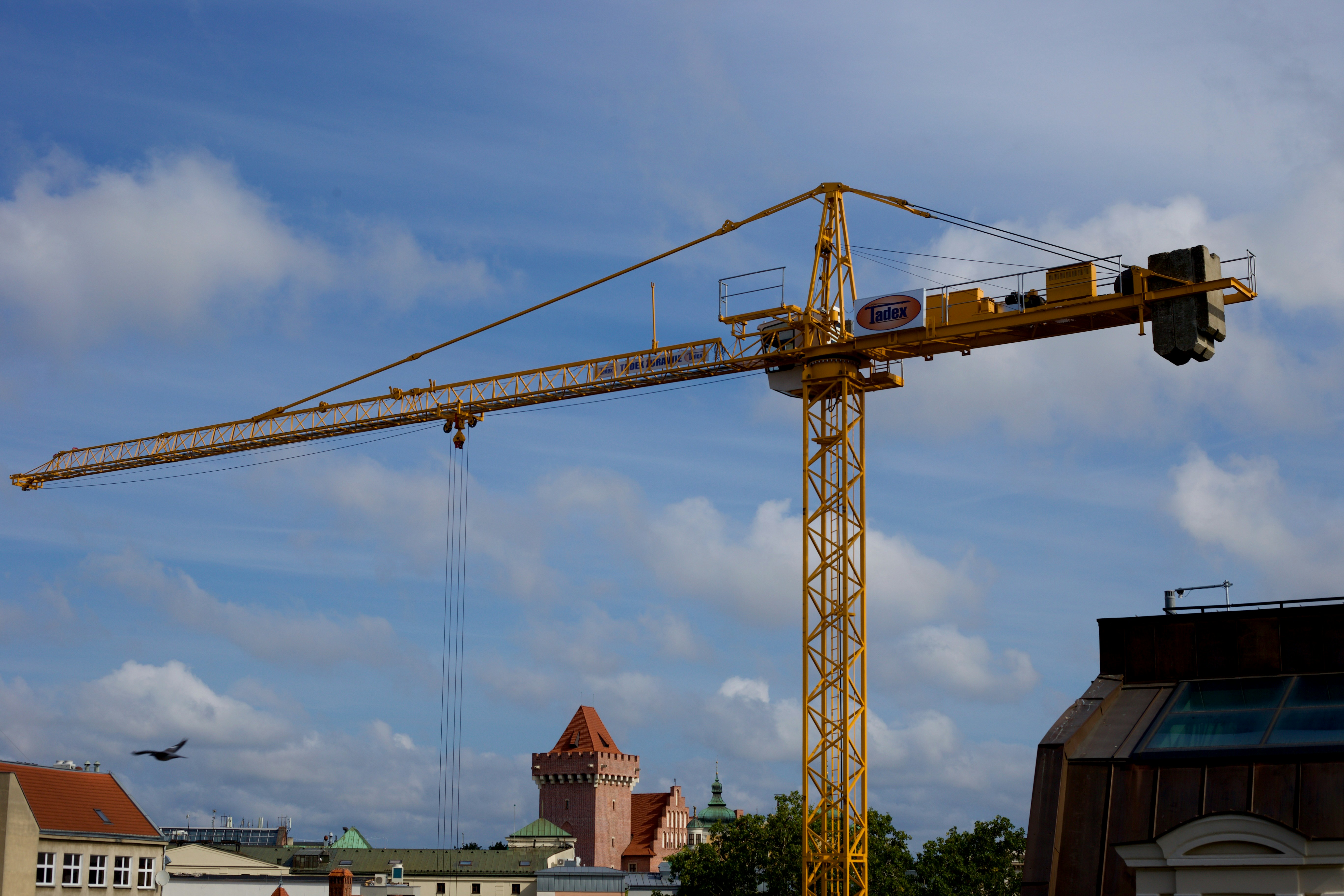A yellow crane is on top of a building
