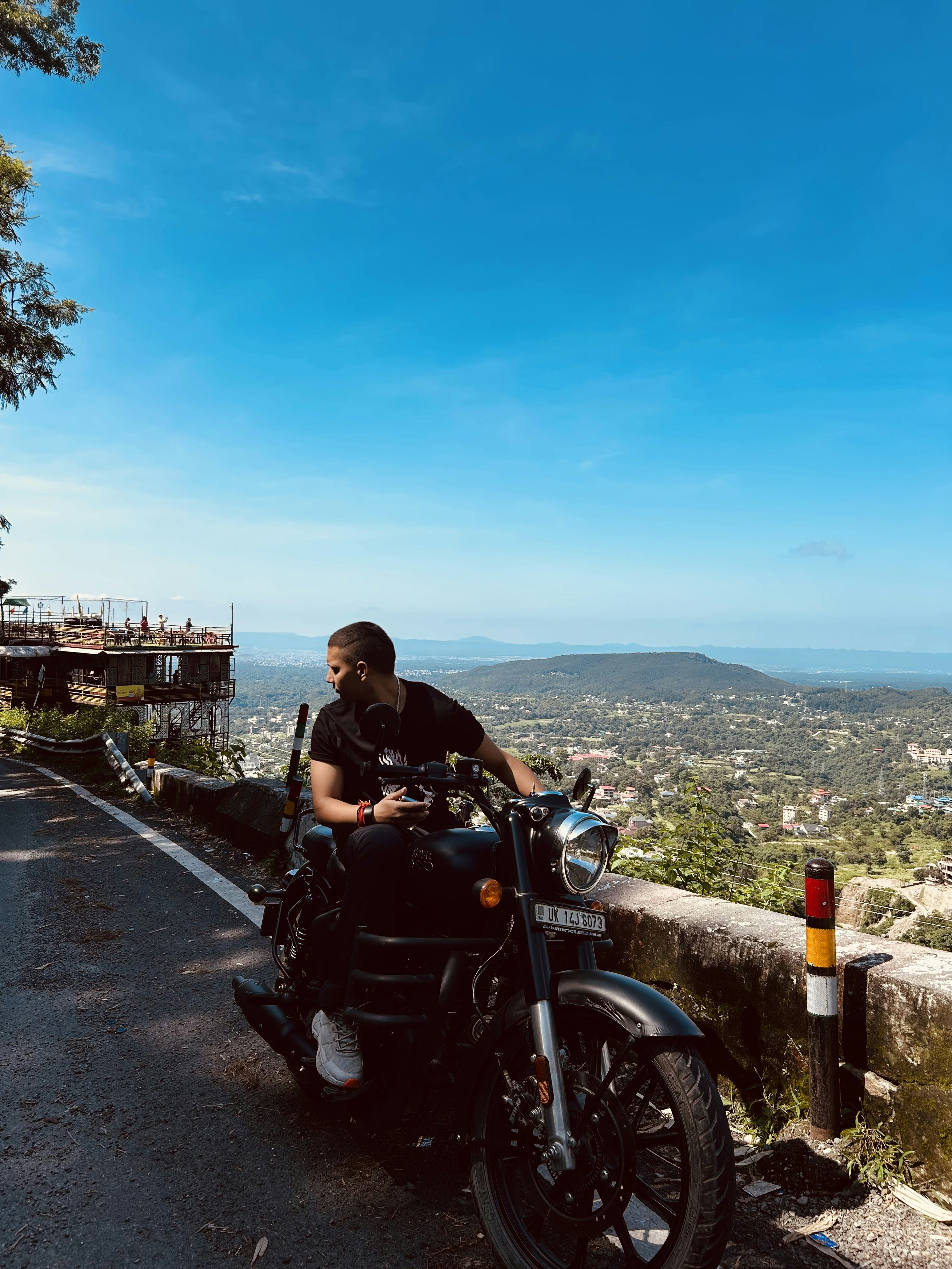 Rider on a Scenic Ridge: A Motorcycle Pause with Panoramic Vistas