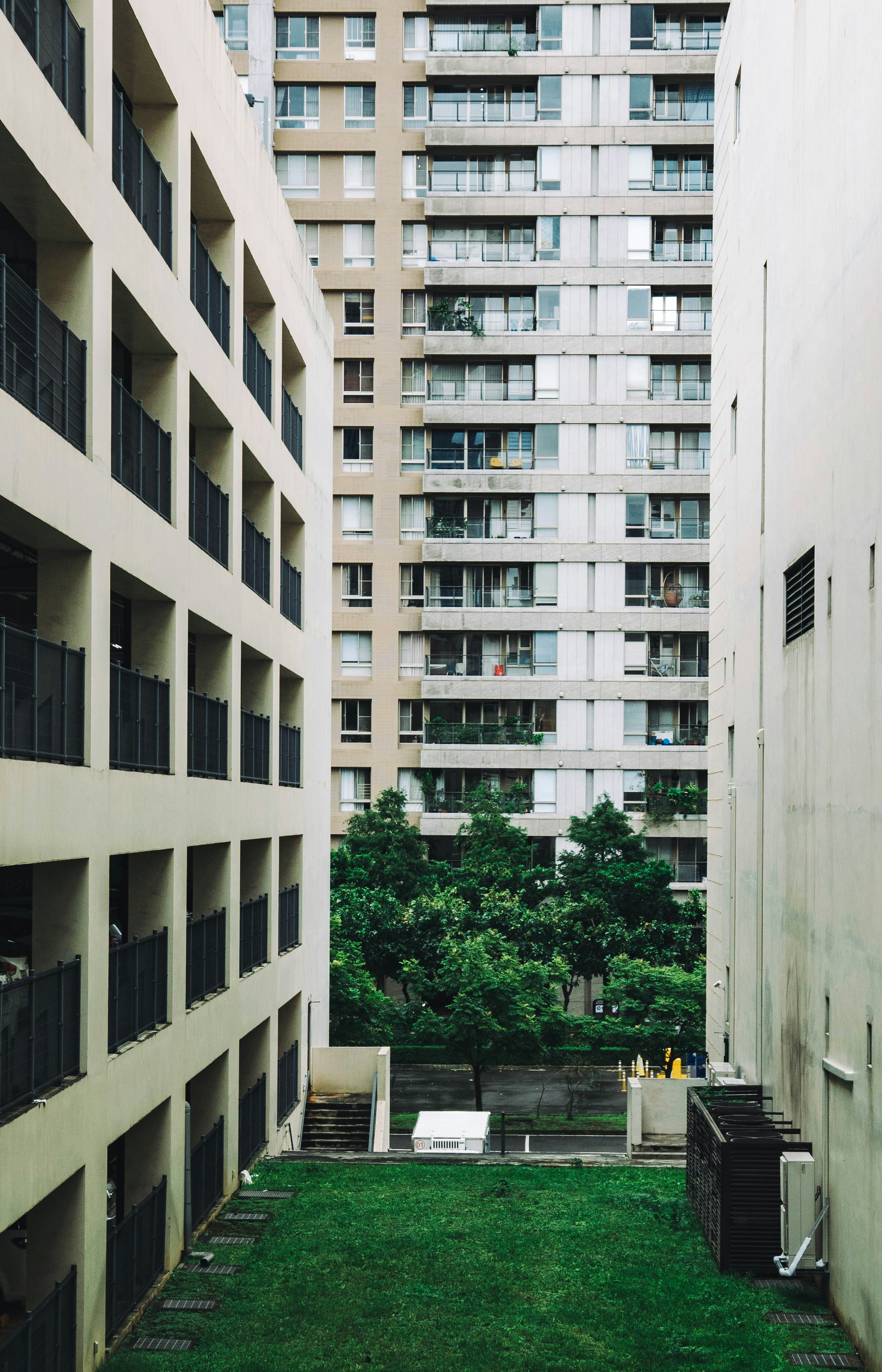 A view of a grassy courtyard between two buildings photo – Free Mitsui ...