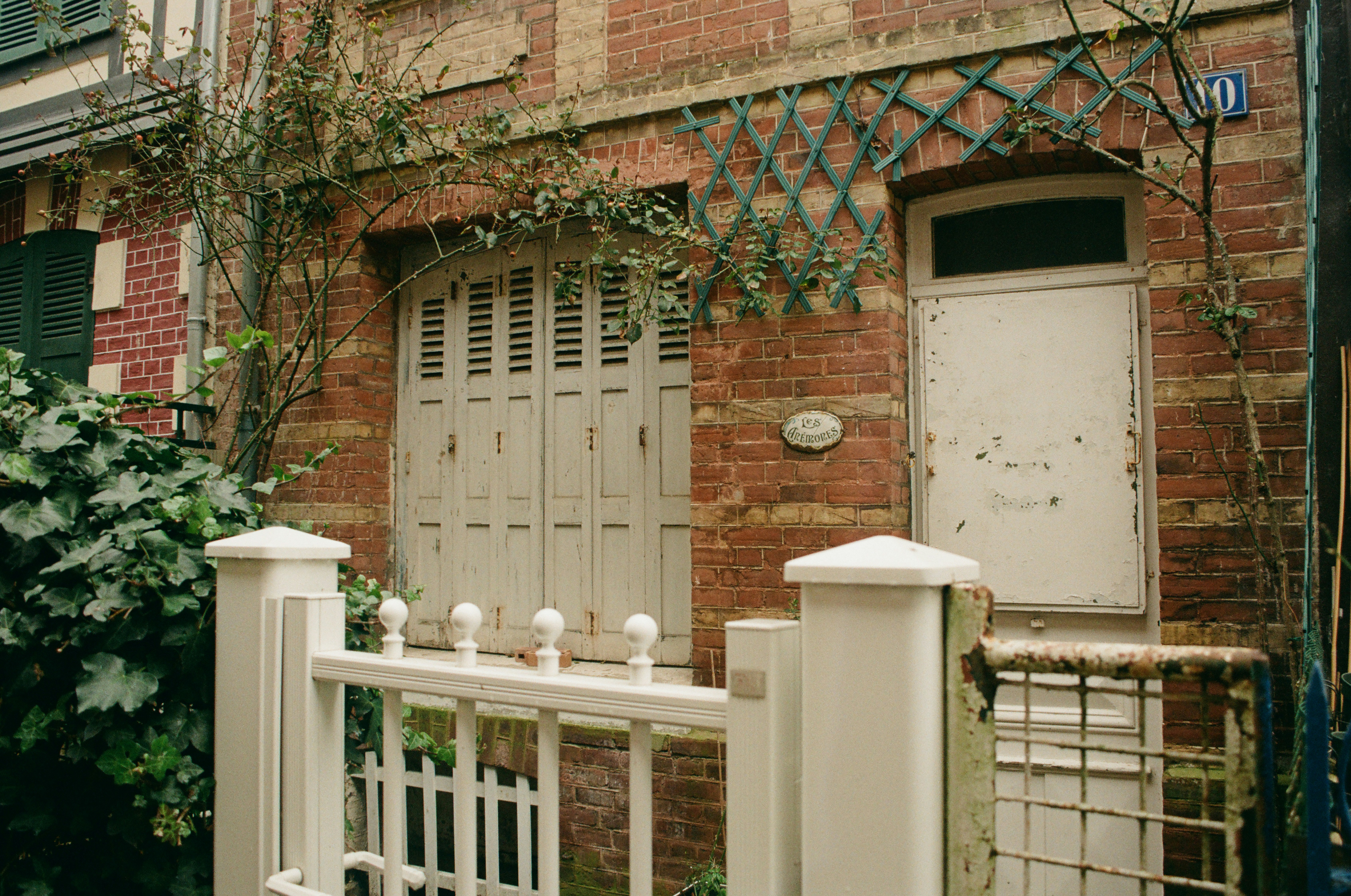 A brick building with a white fence and gate photo – Free City Image on ...