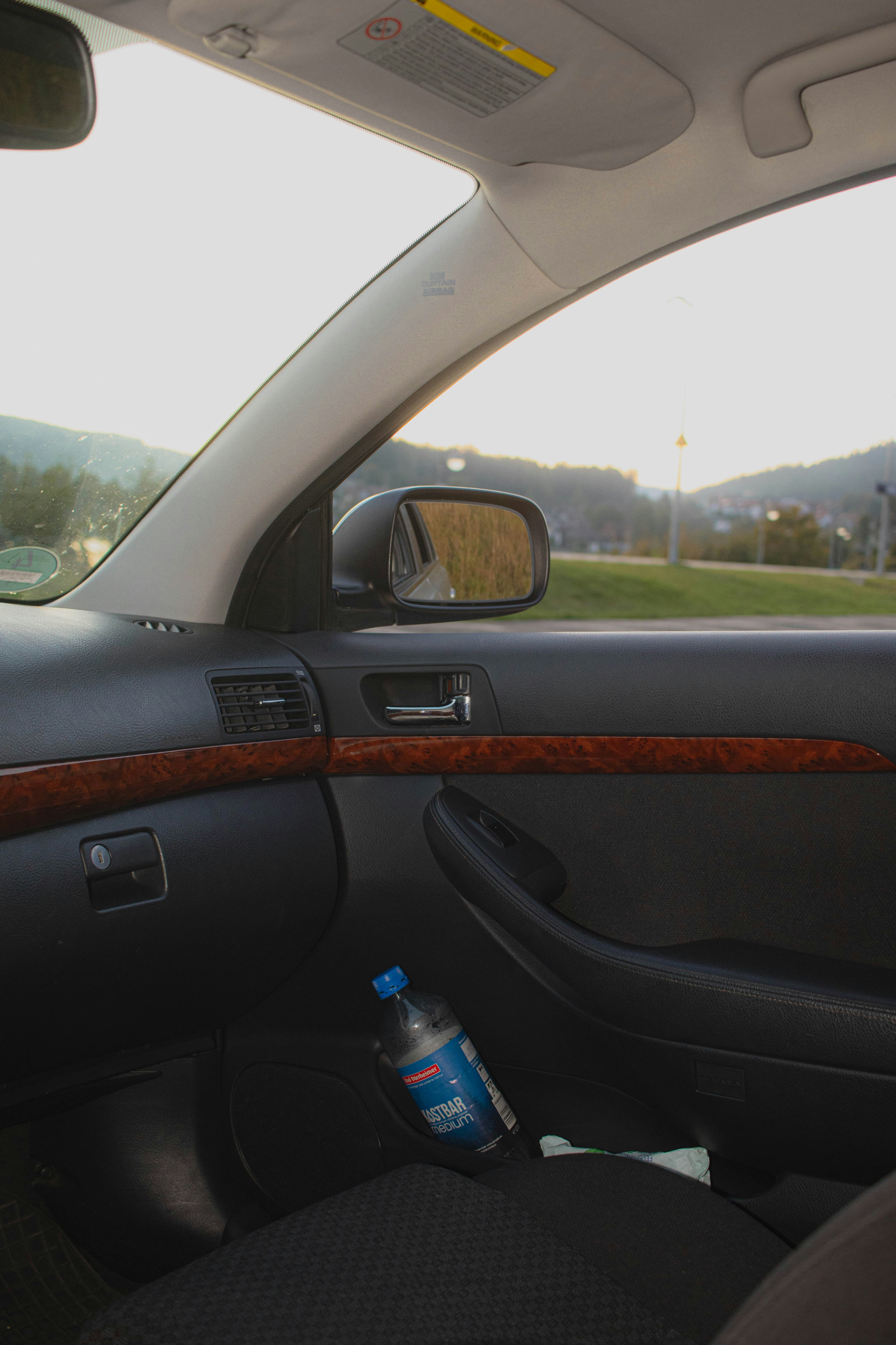 Sunlit Cabin: A Water Bottle Anchors the Passenger-Side Interior