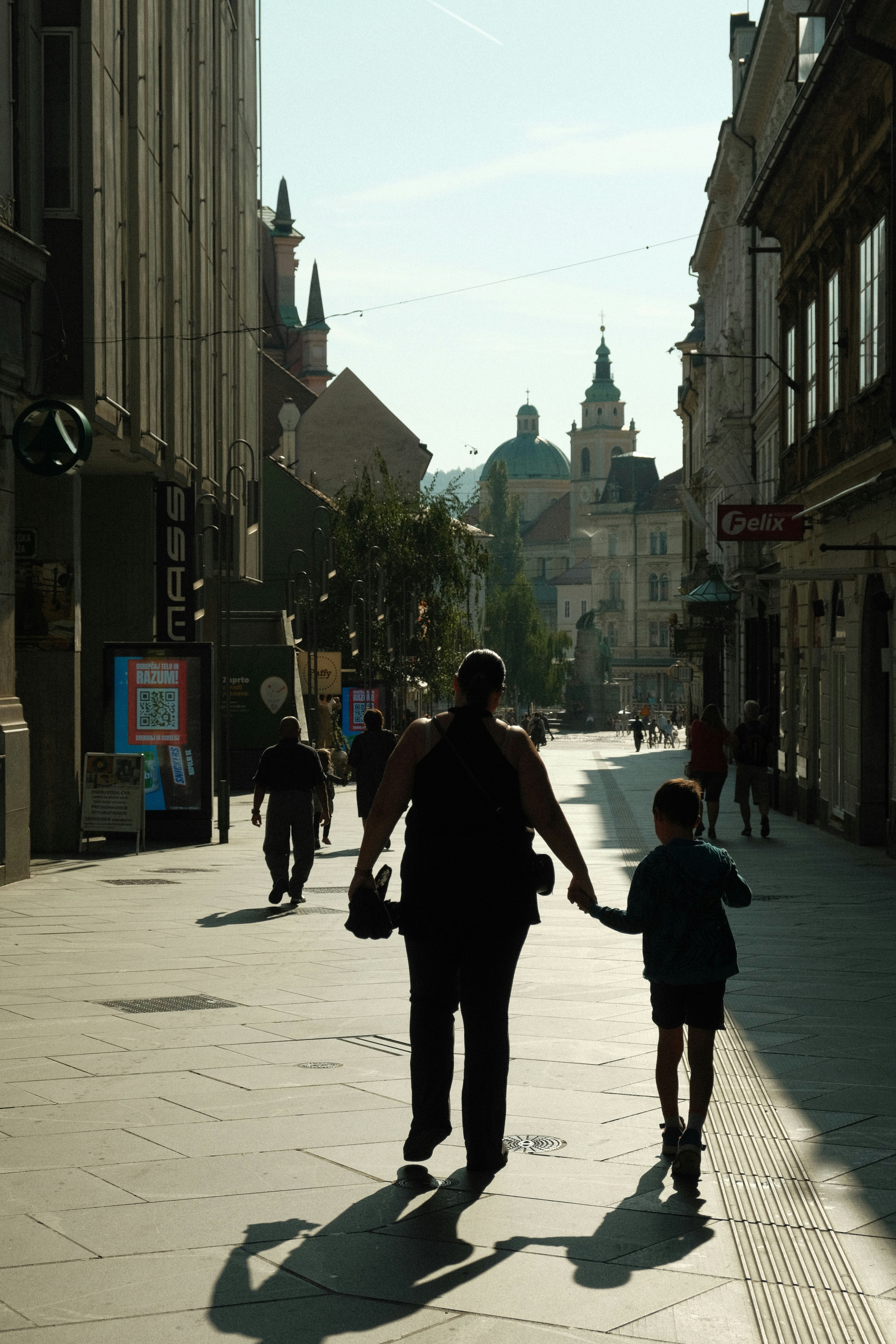 Hand-in-Hand Through a Dappled City Street